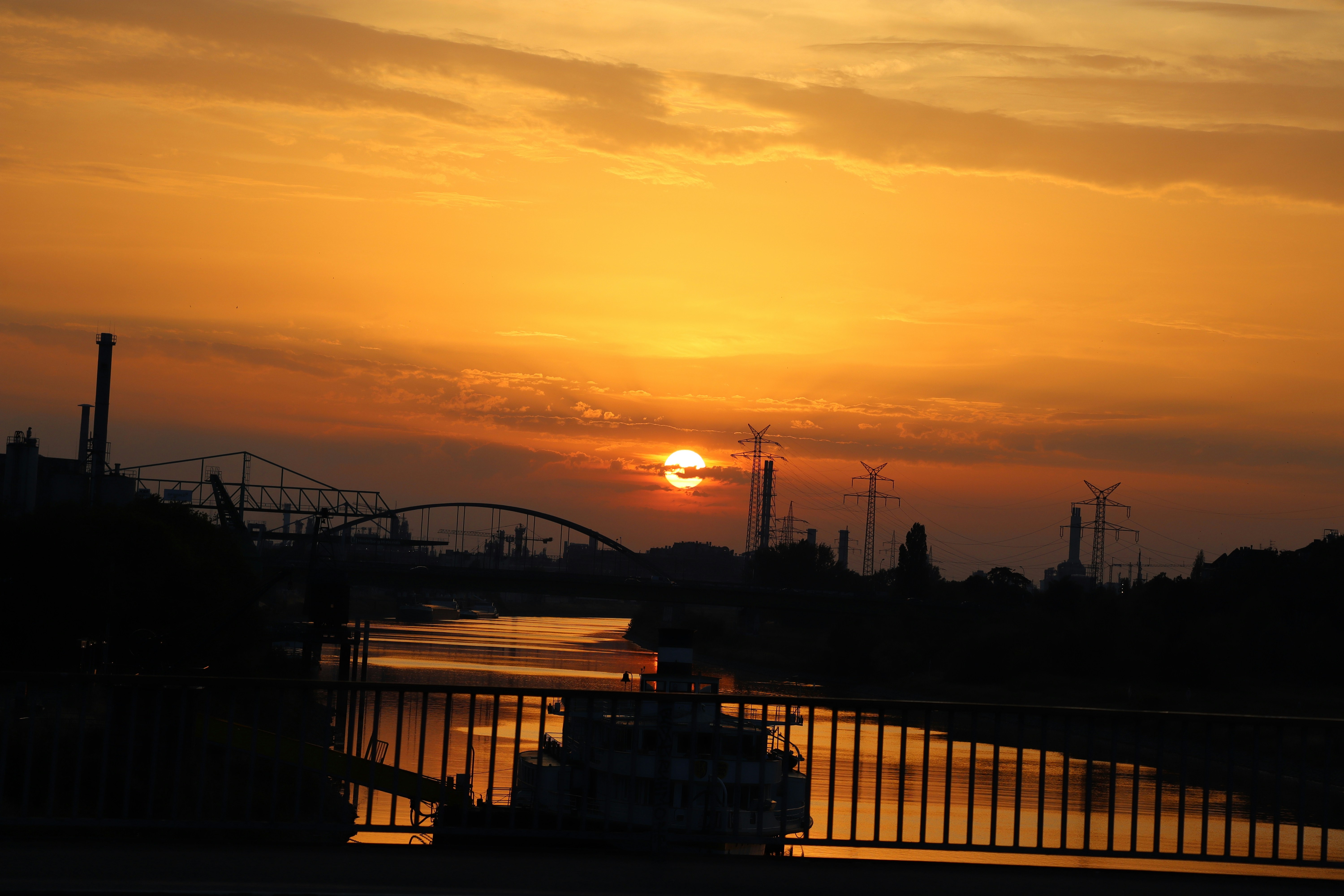 Sunset Over the River: silhouettes and industrial skyline