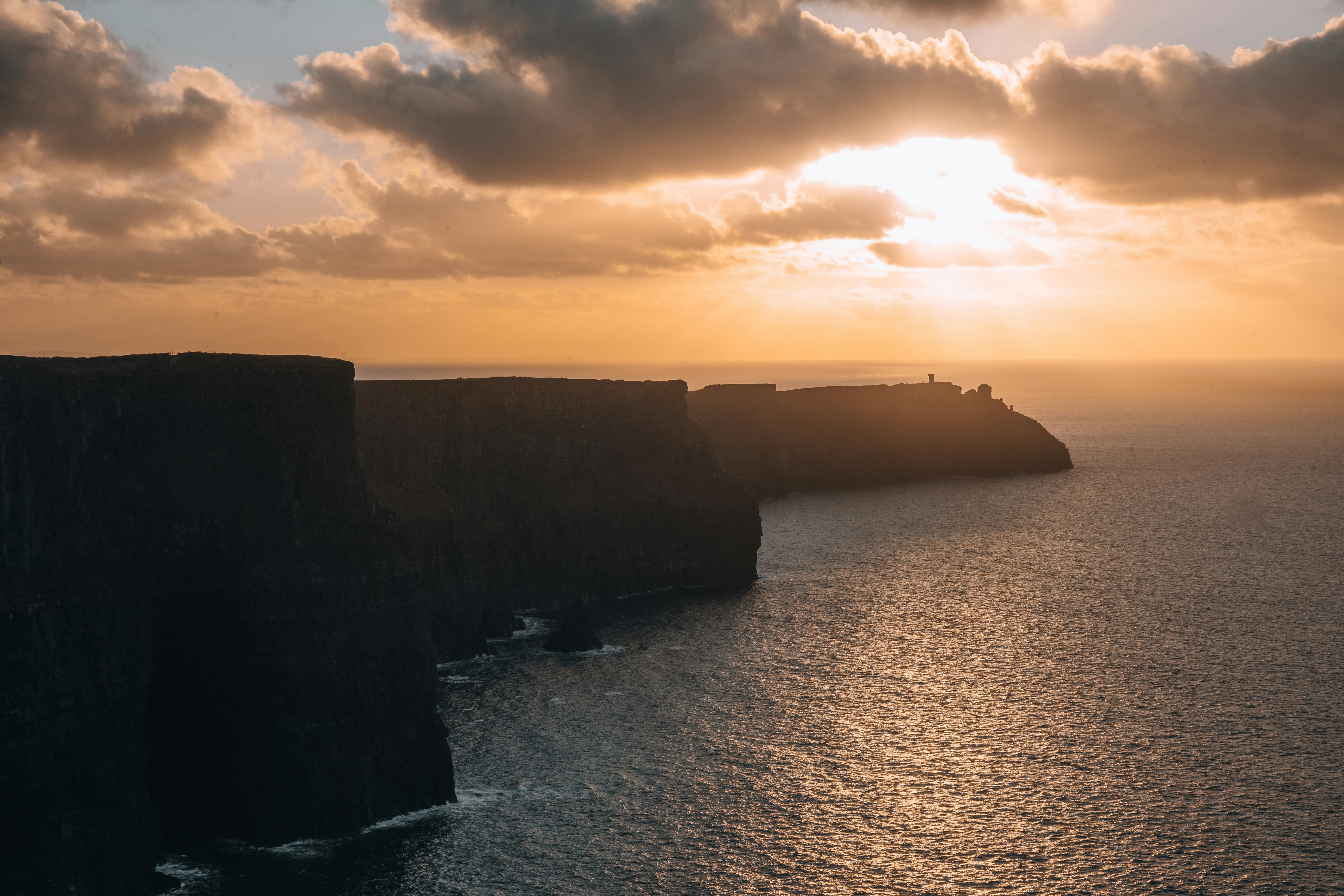 Sunlit Cliffs Over Calm Atlantic at Dusk