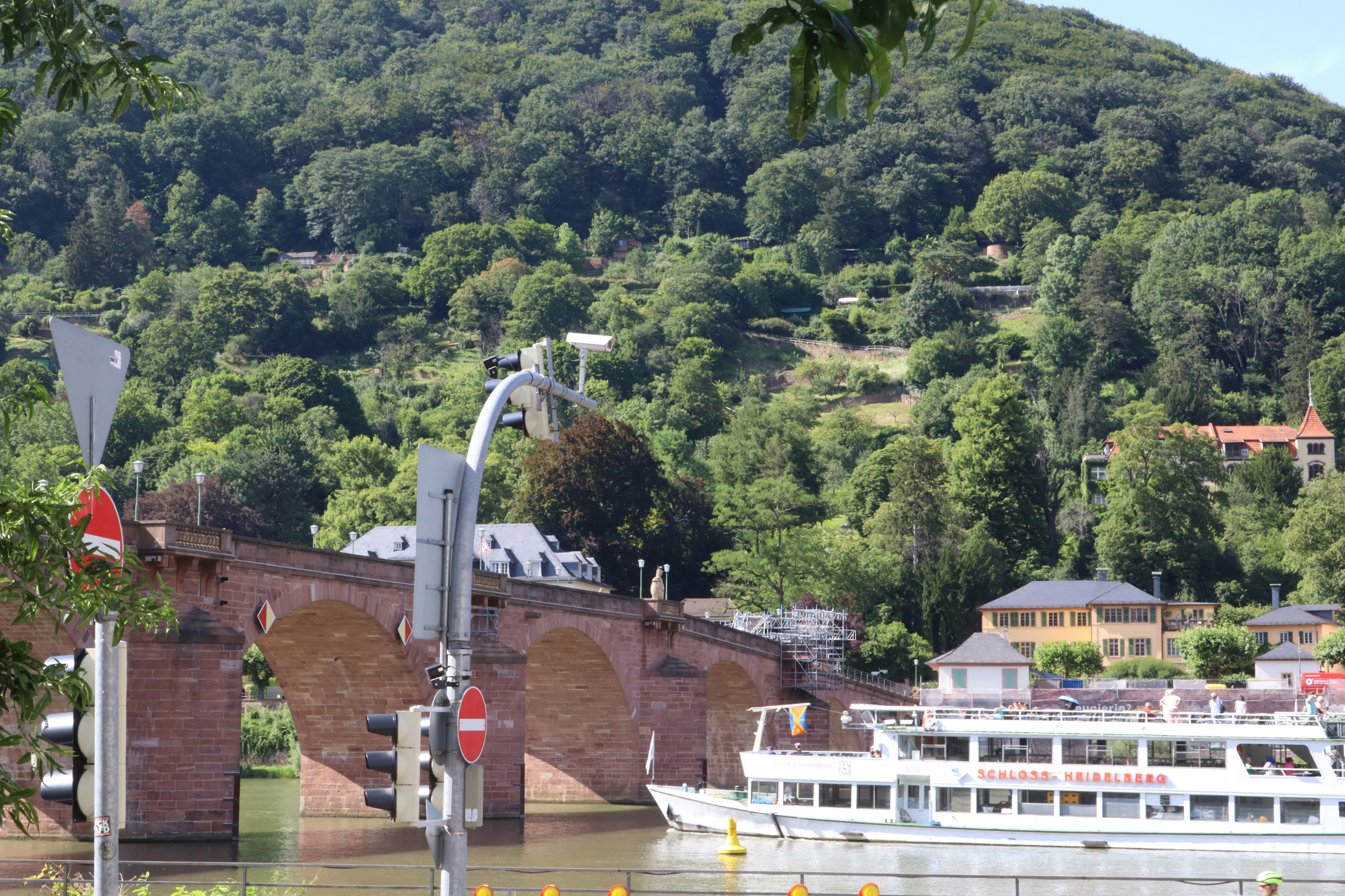 Riverfront Bridge and Boat Hub under Verdant Hill
