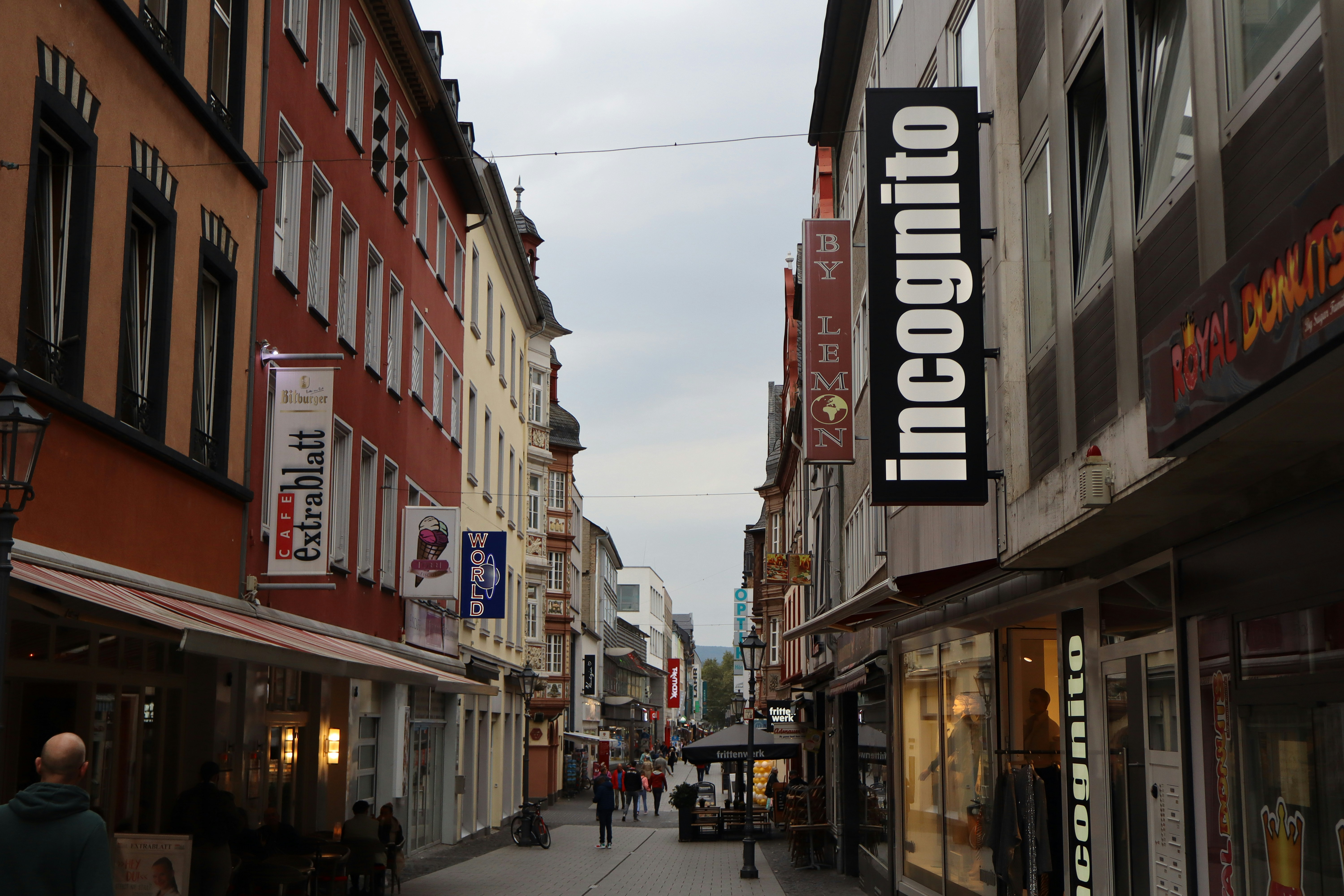 Cobbled Street Corridor: Shops, Signage, and Pedestrians in a Scandinavian-tinged Passage