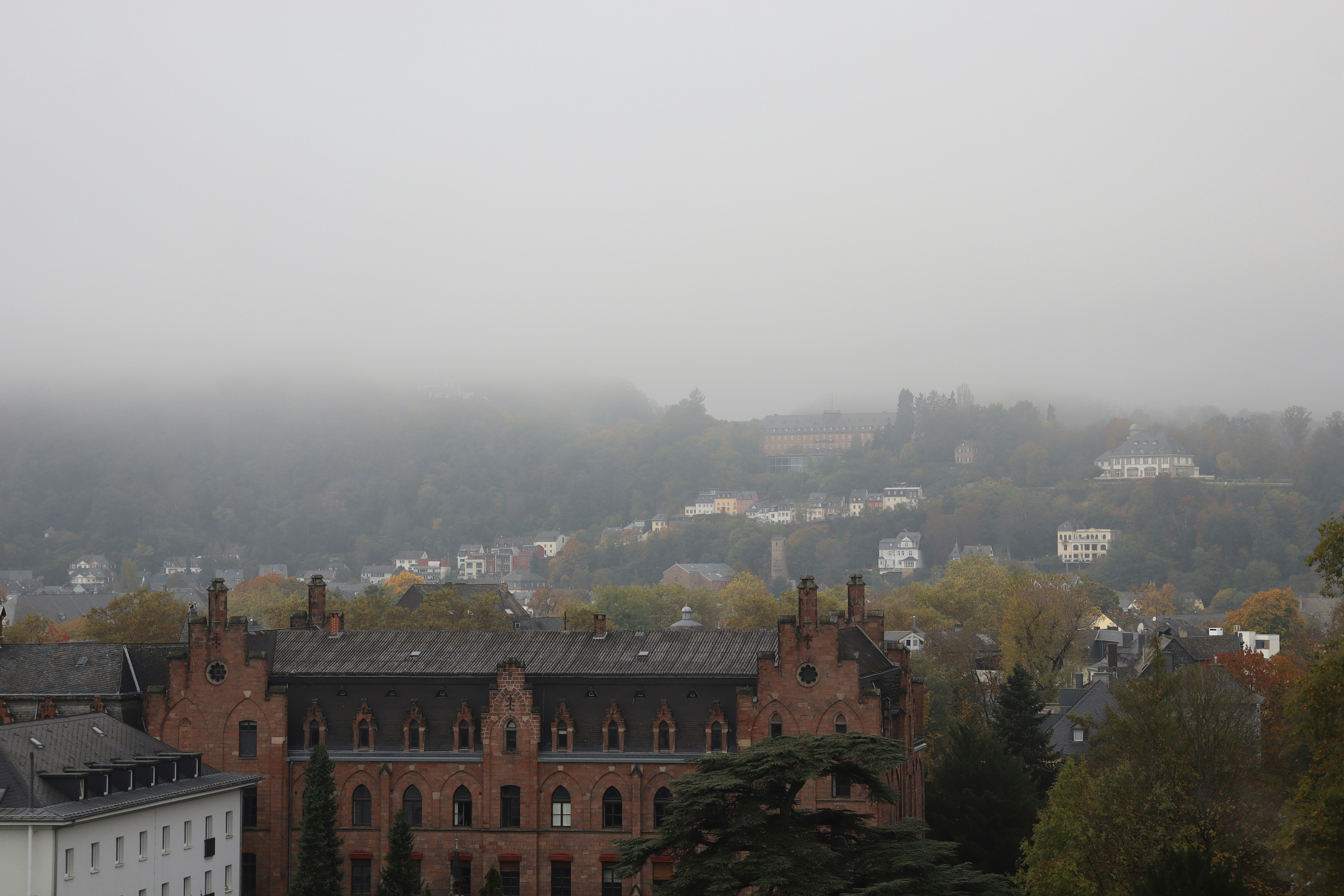Misty Ridge: Historic Red-Brick Edifice Under Clouded Dawn