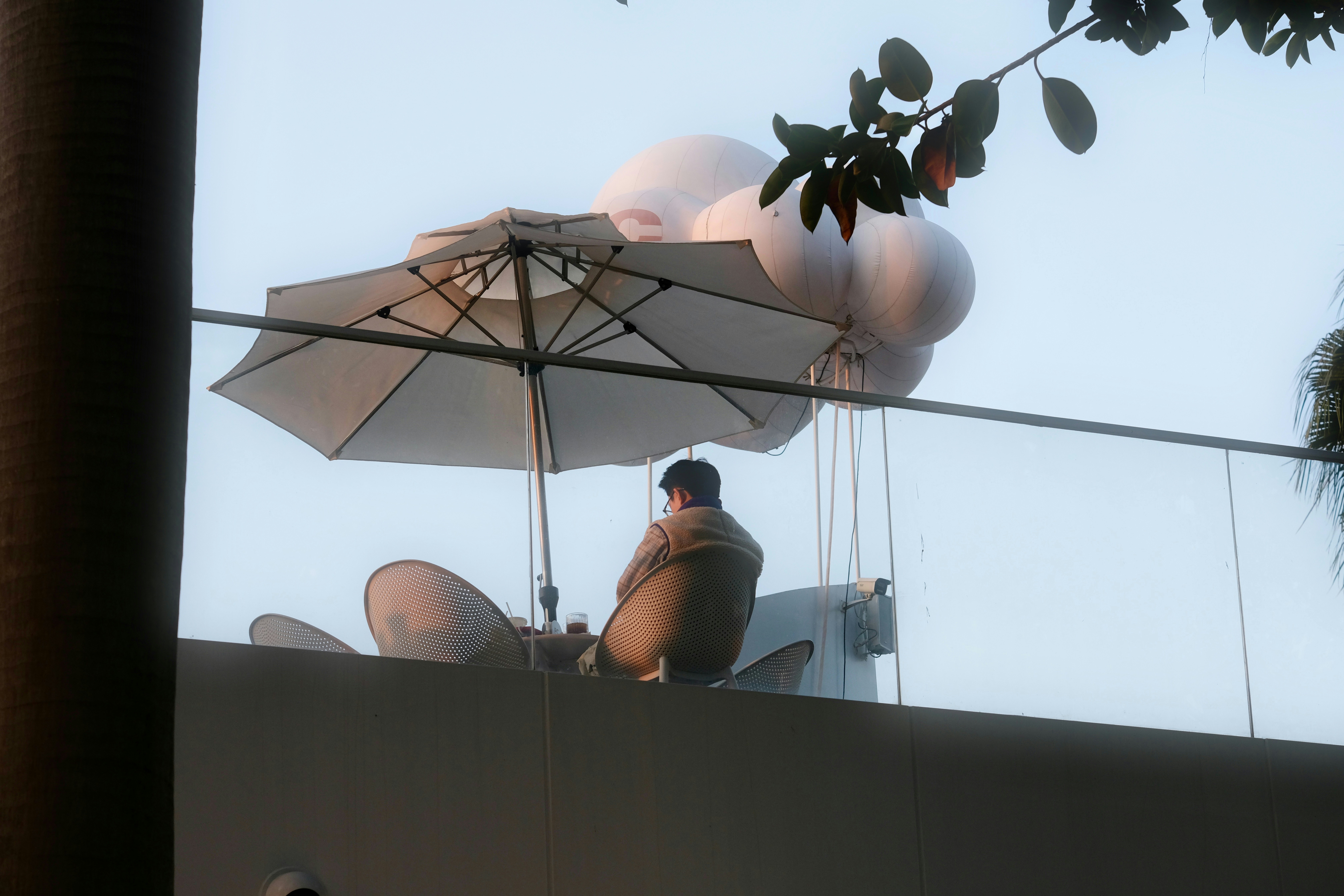 Rooftop Quiet: A Solitary Moment Under the Parabolic Umbrellas
