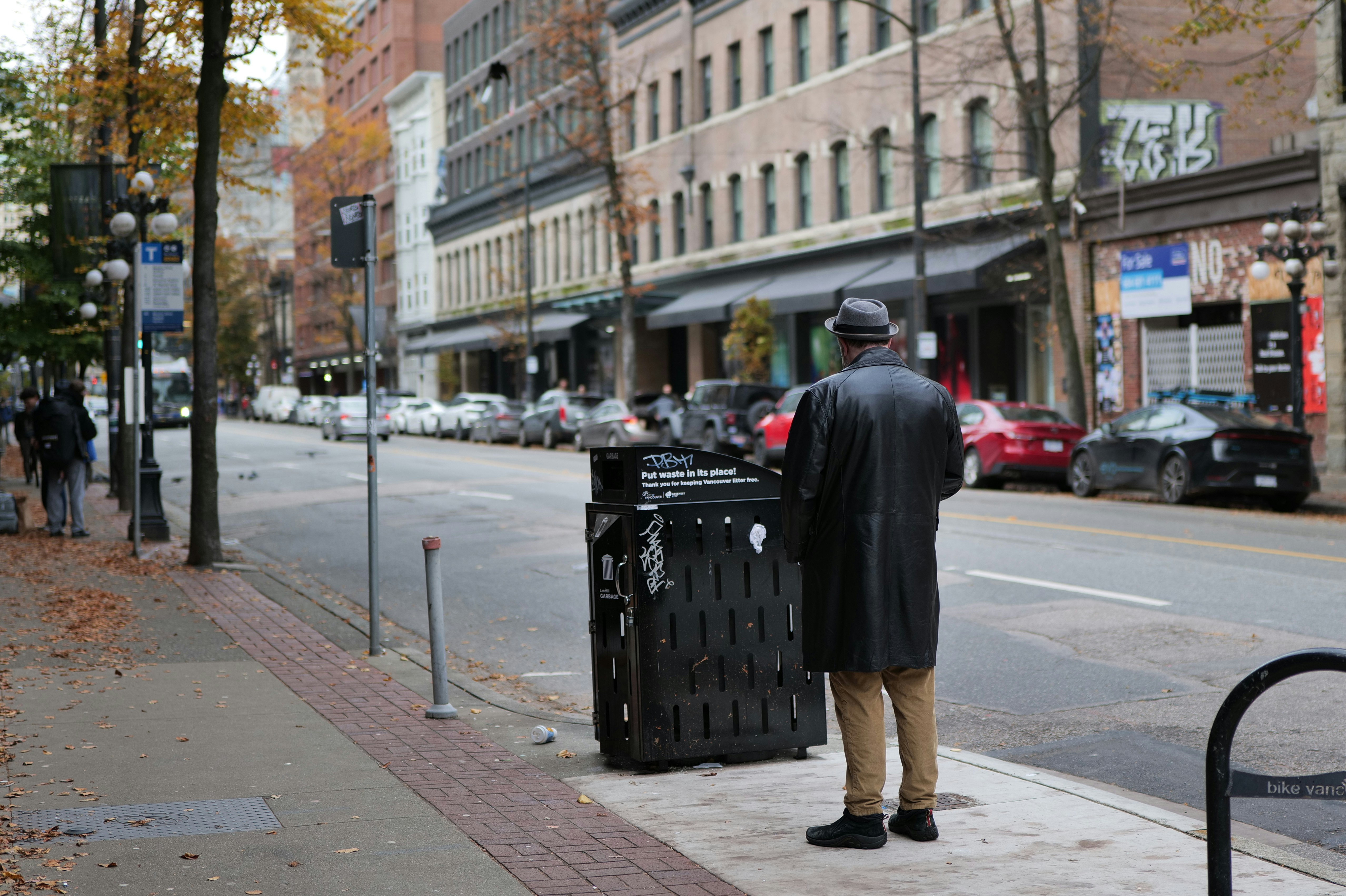 Street Corner Portrait: Man in a Hat at the Curb
