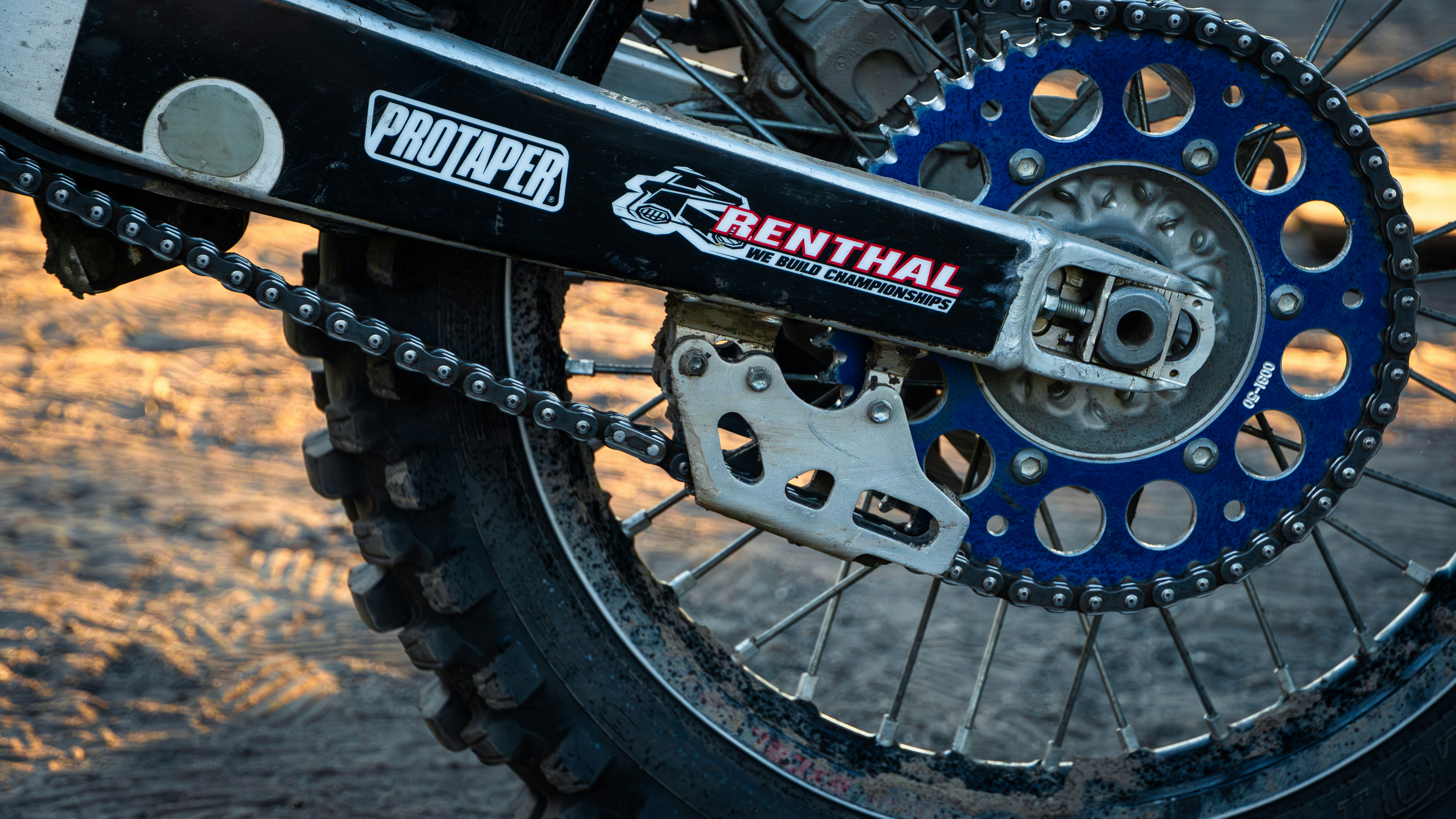 Close-up of a dirt bike's rear wheel and chain