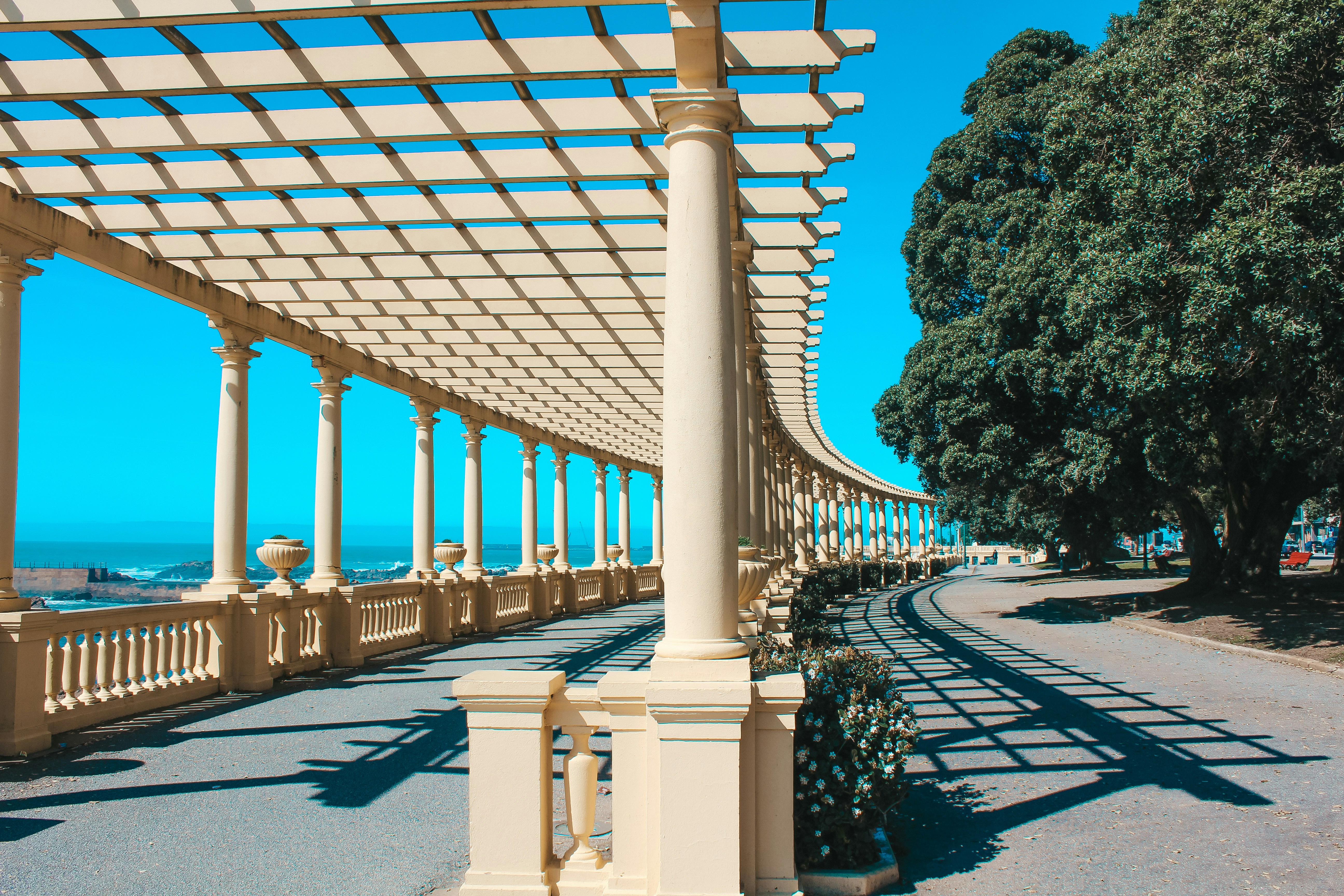 Colonnade in the Sea Breeze: Shadowed Pergola Stretch by the Waterfront