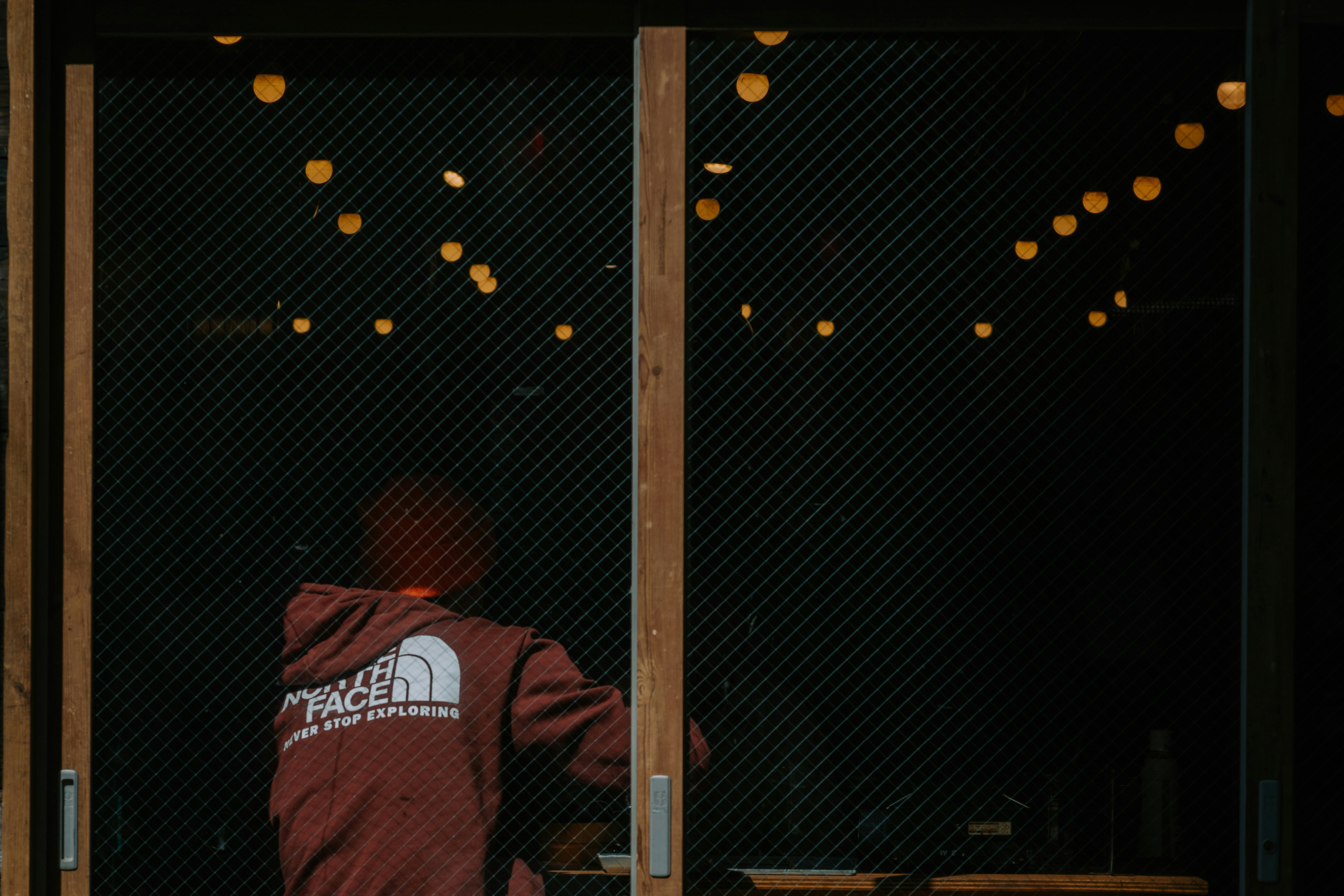 Person in a jacket entering a dark room with lights.