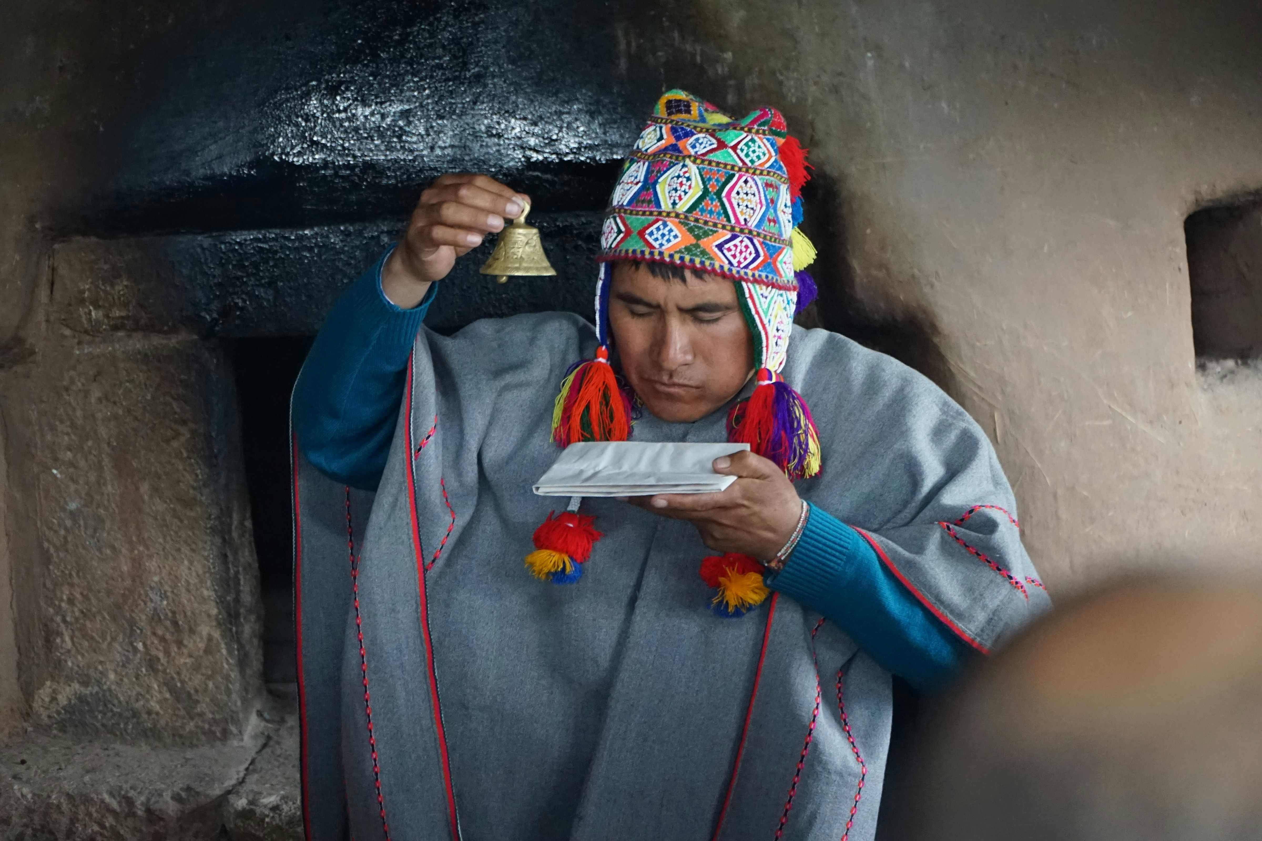 Sacred Bell Worker in Colorful Knit: A Moment at the Hearth