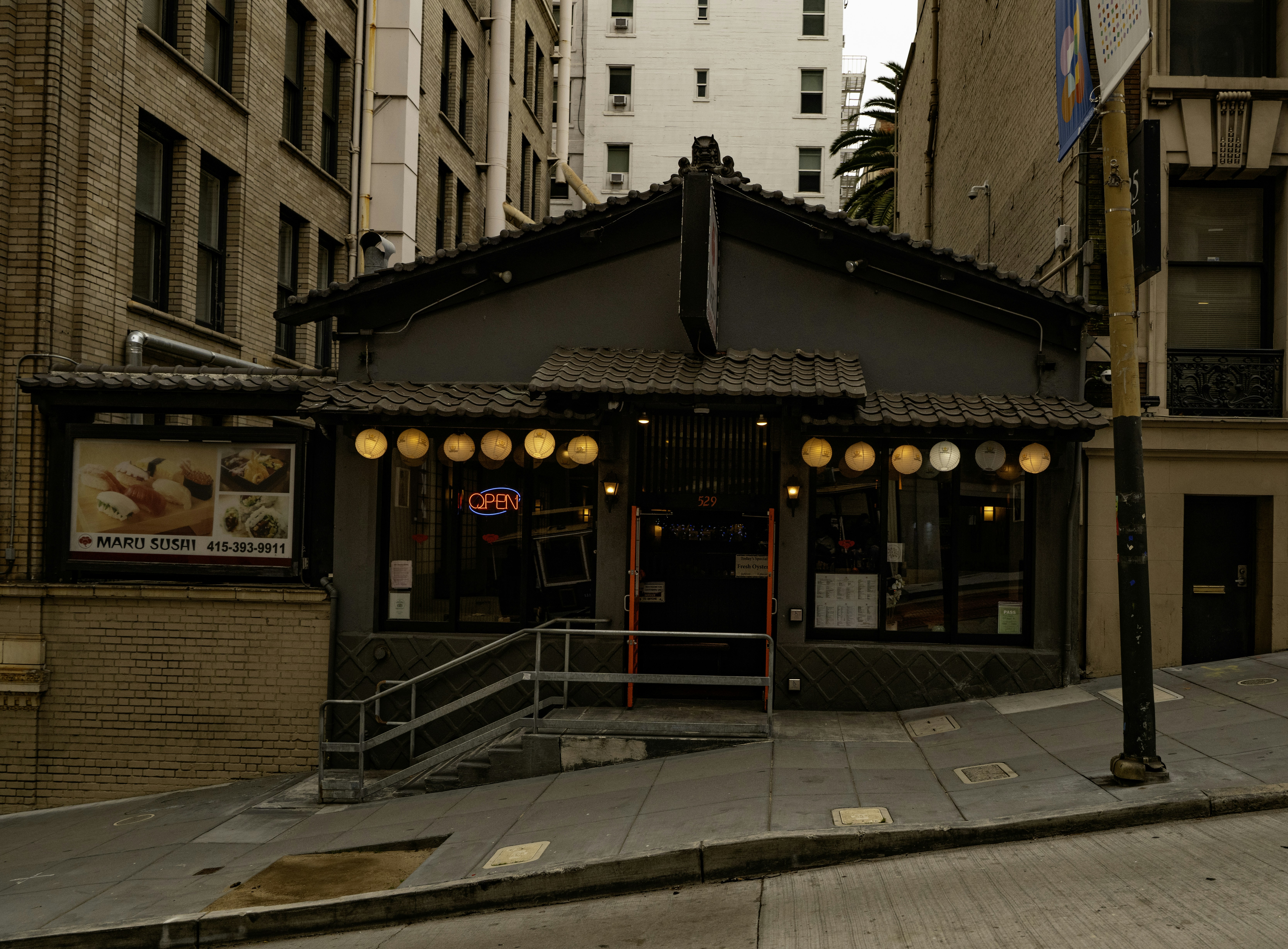 Old Chinatown storefront lit by lanterns at dusk
