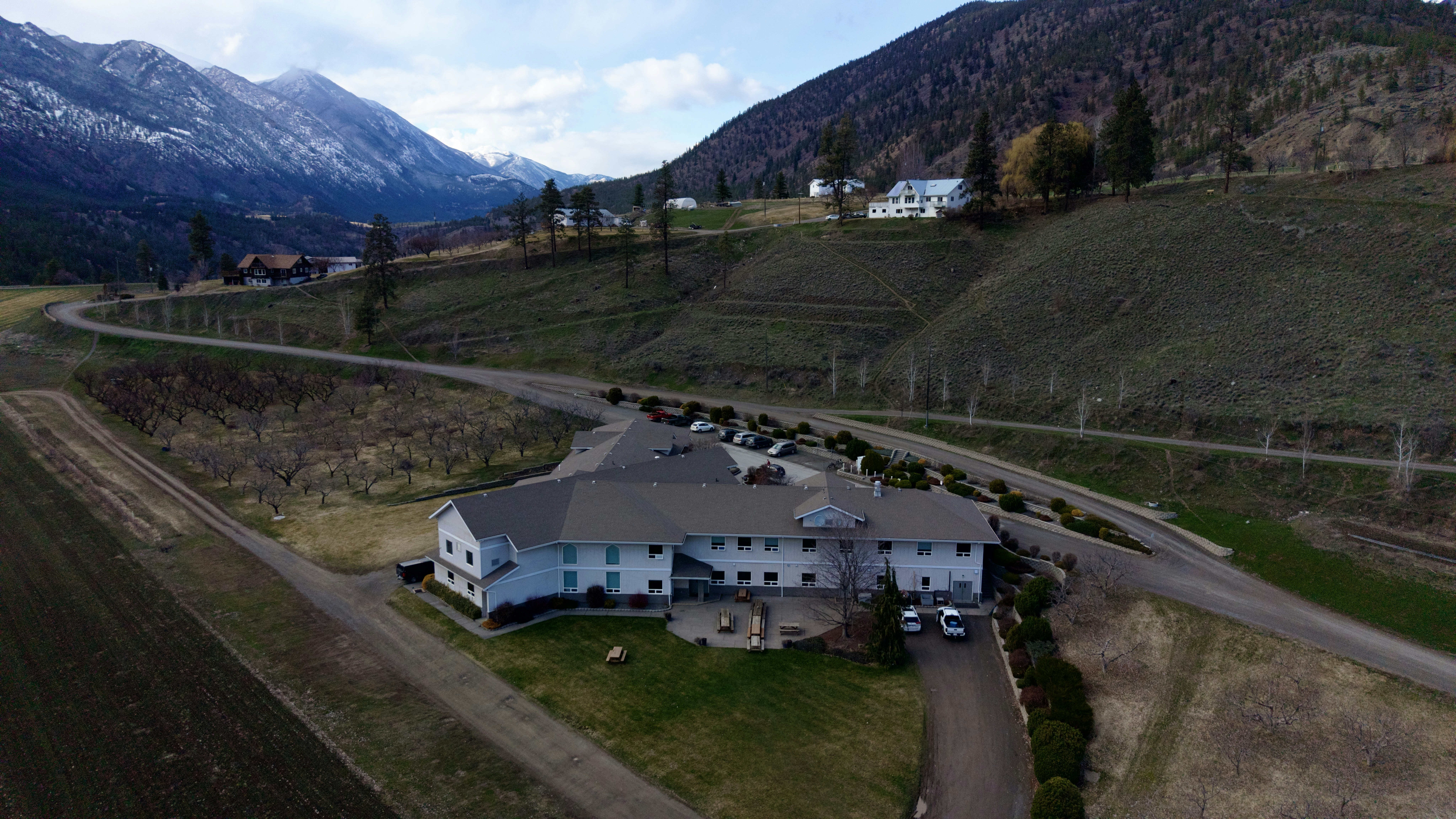 Aerial View of a hillside lodge with winding road and distant mountains