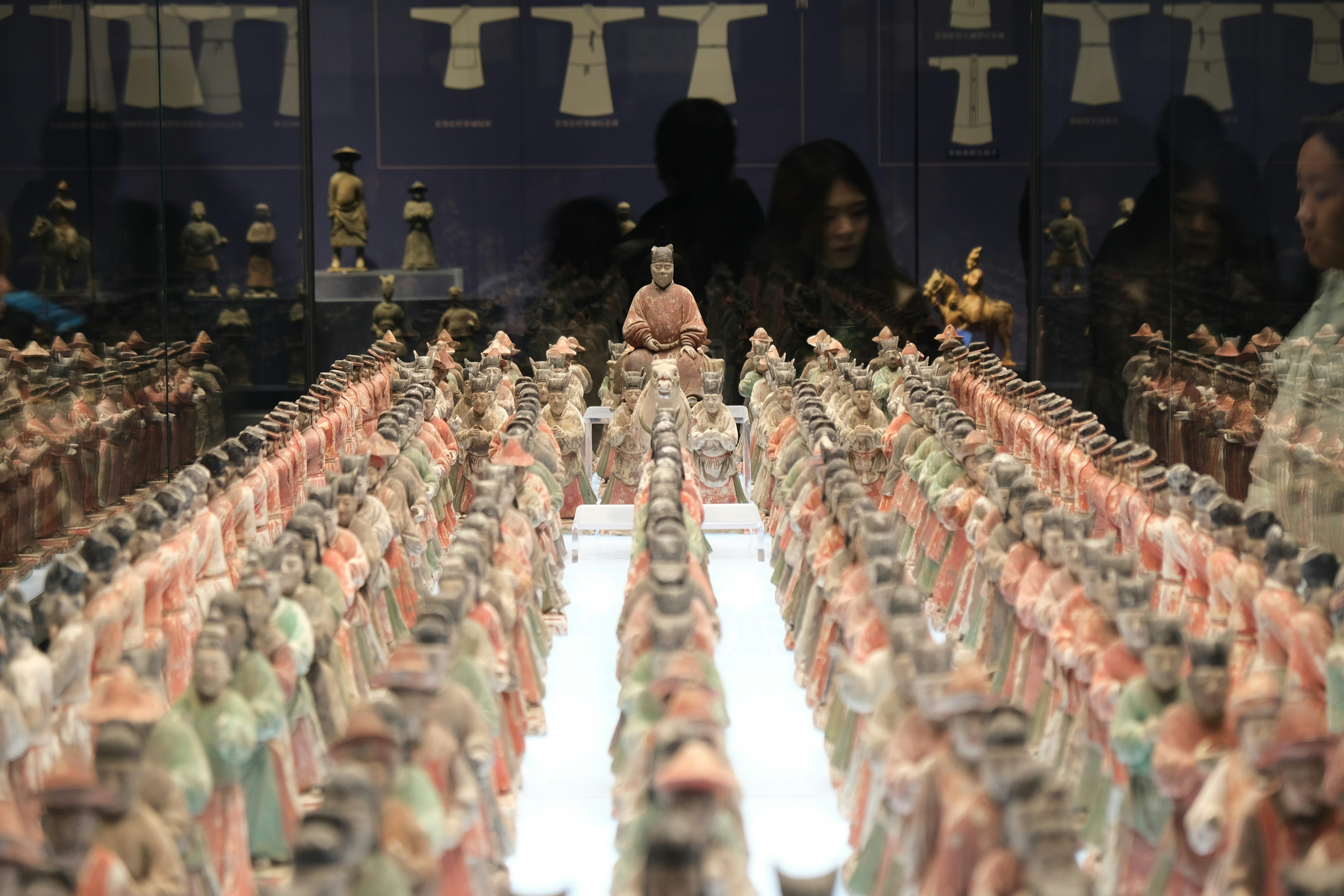 Rows of Tiny Figures Guarding a Central Figure in a Glass Display