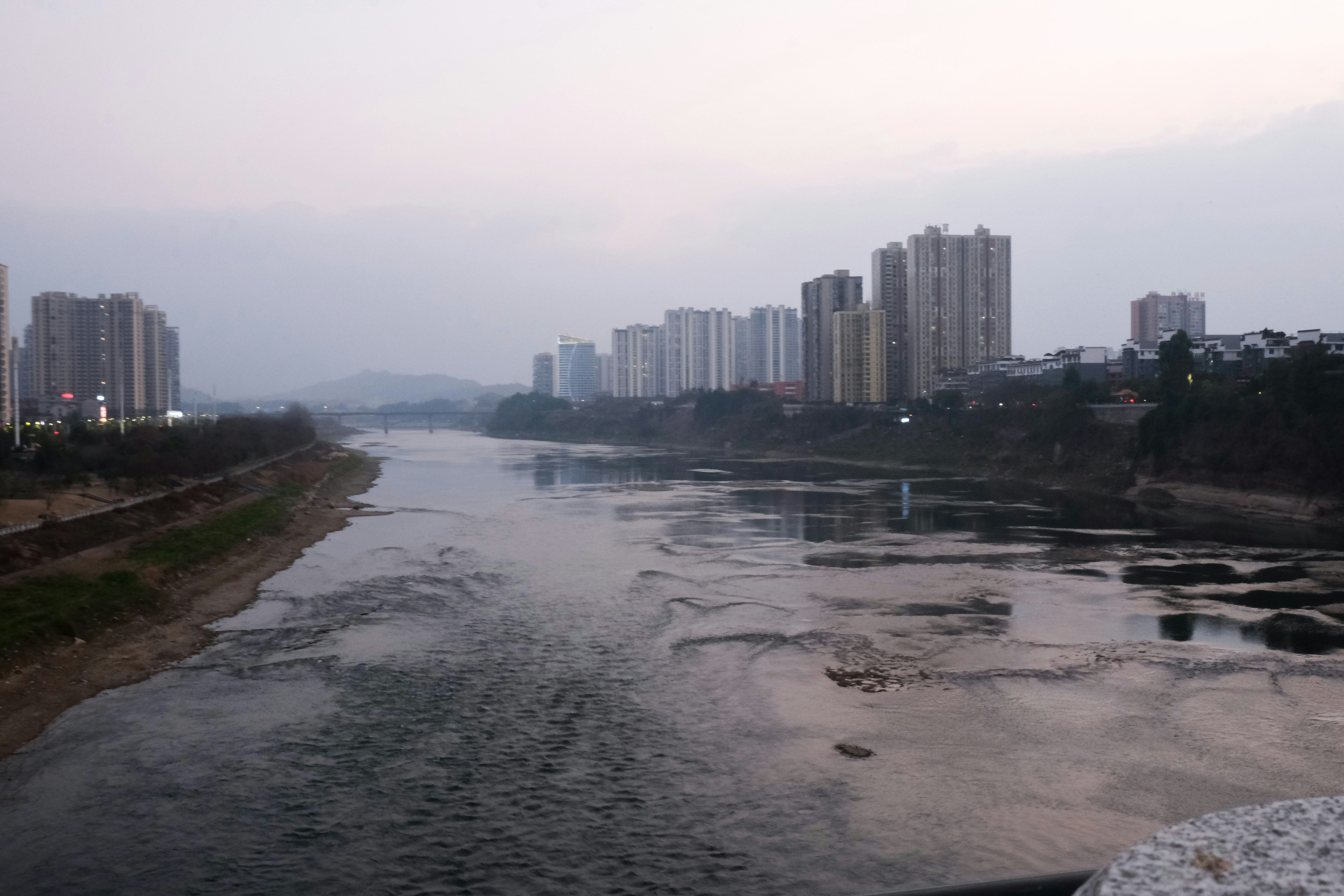 City Edge Reflections: Evening River Between Towers