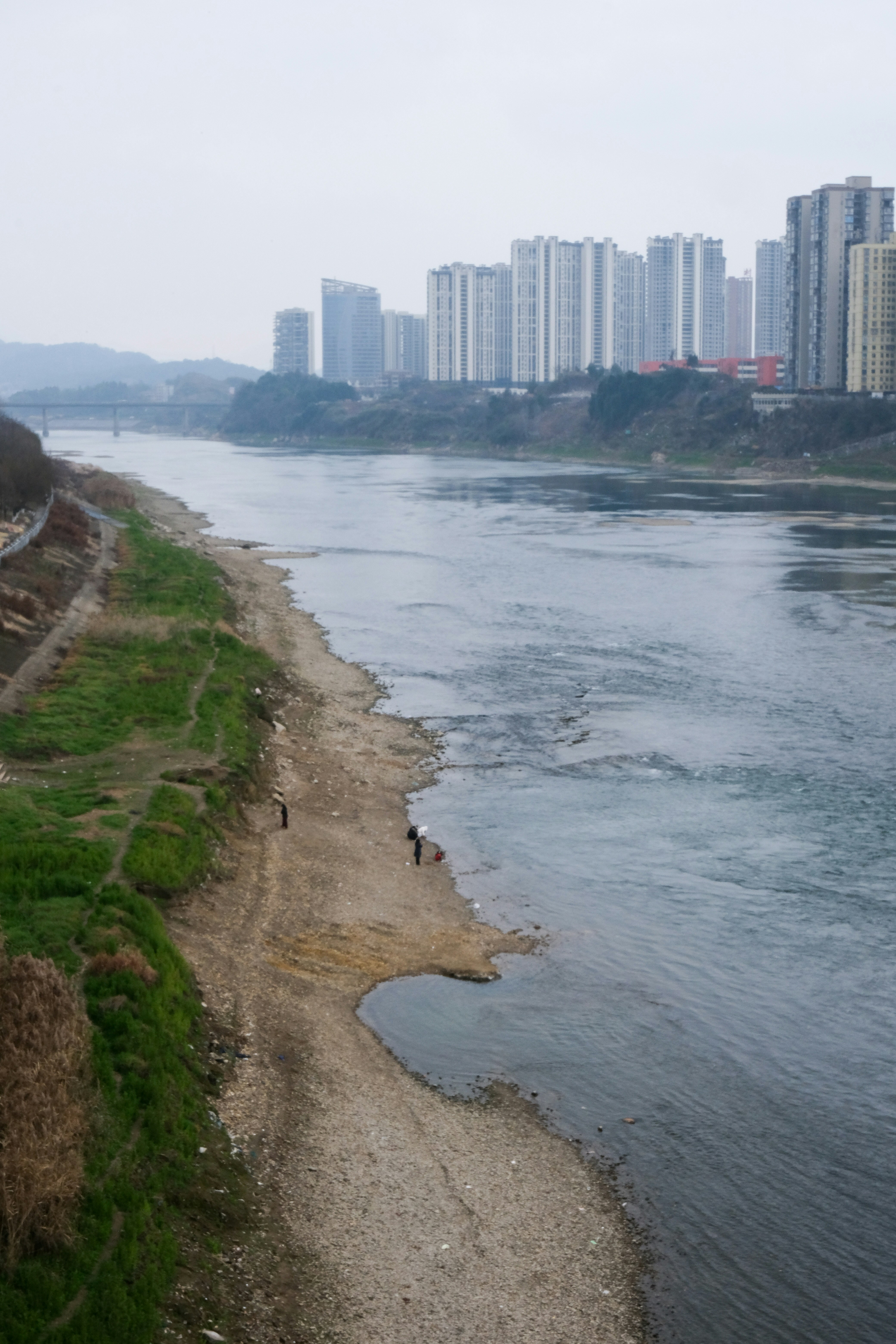 Riverside Narrow Beach with Urban Backdrop