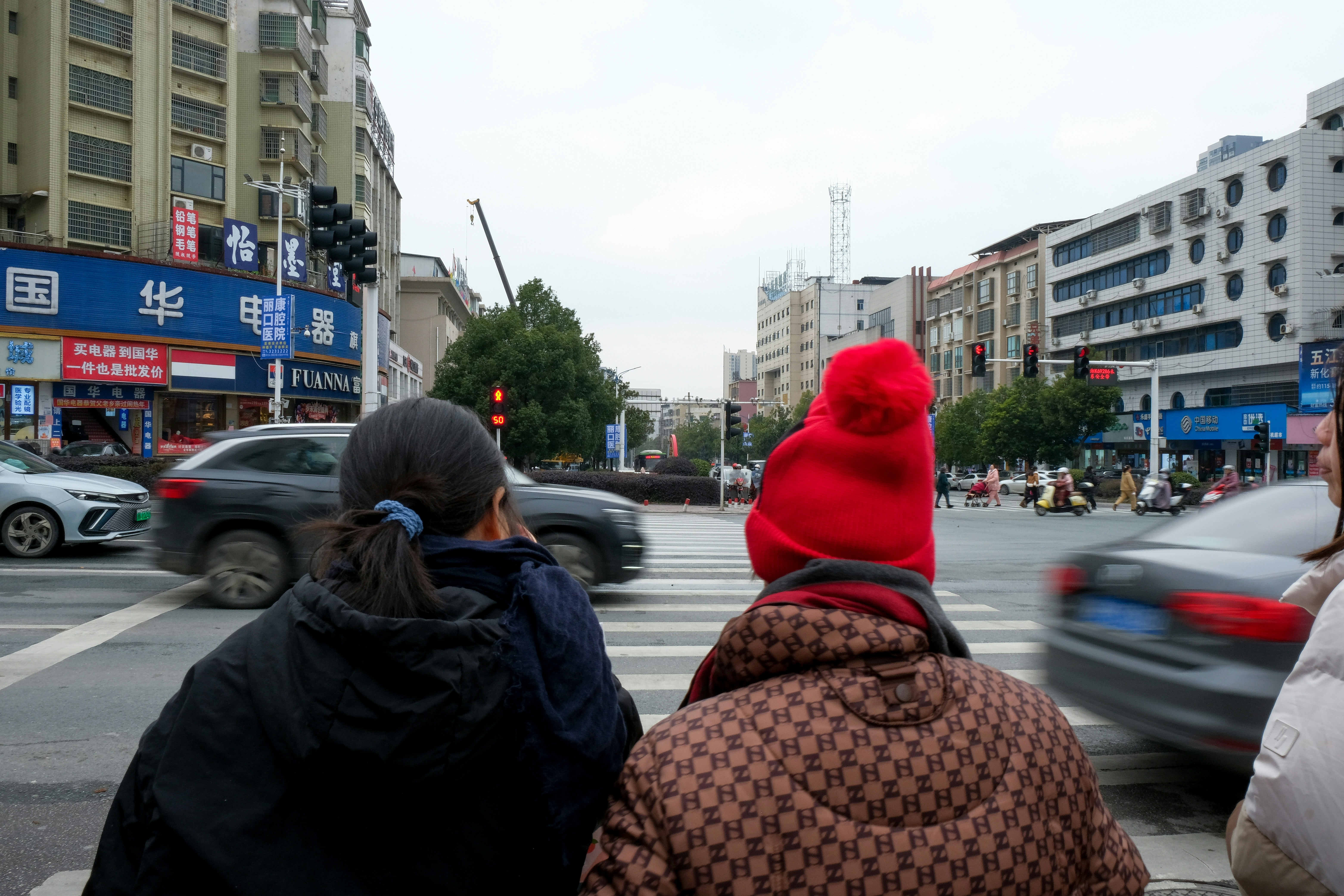 Crosswalk Keepers: Two Pedestrians Enter a Busy City Intersection