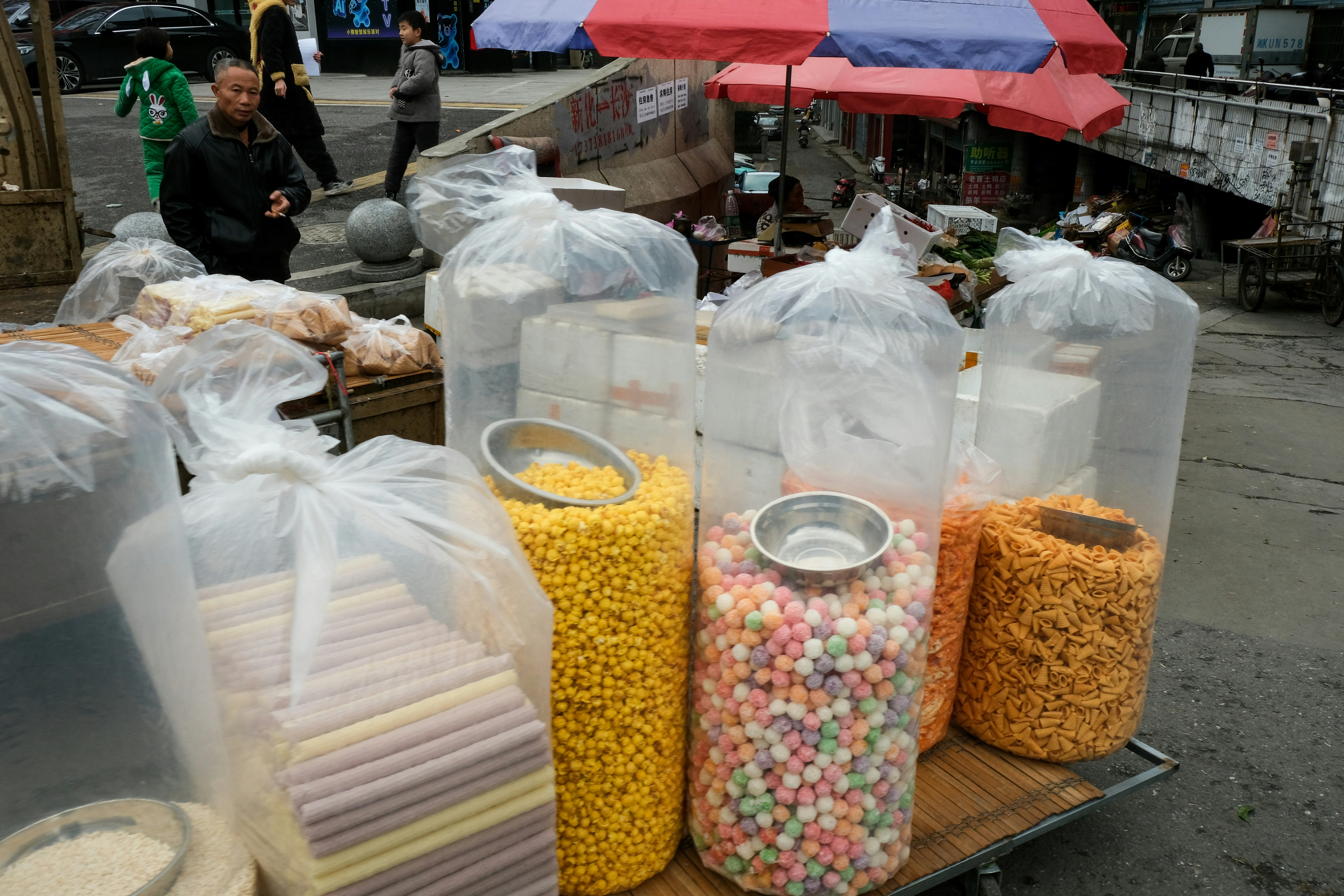 Colorful candies and snacks displayed in large plastic containers.