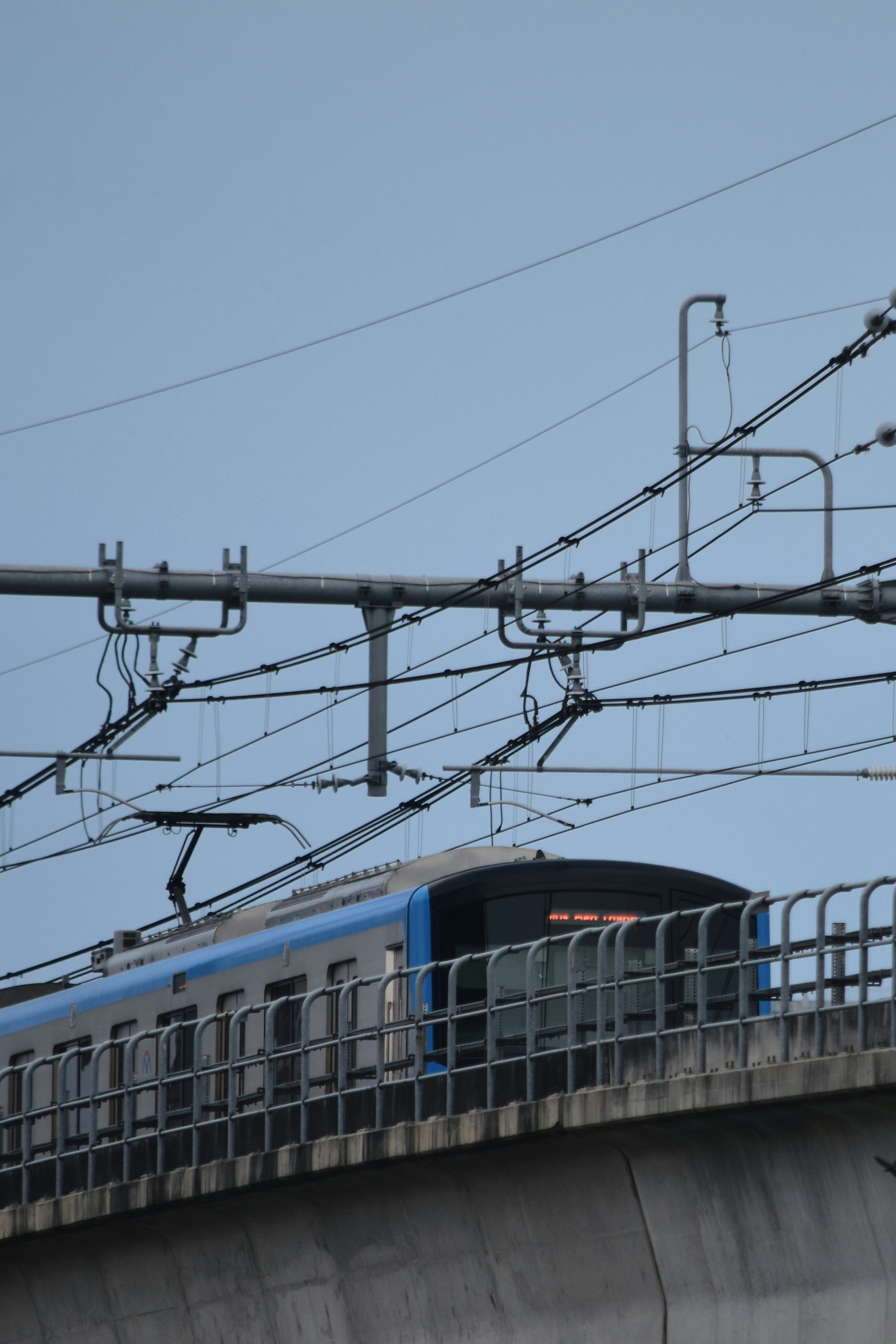 Railway in Motion: A Blue Train Crossing the Sky-Above