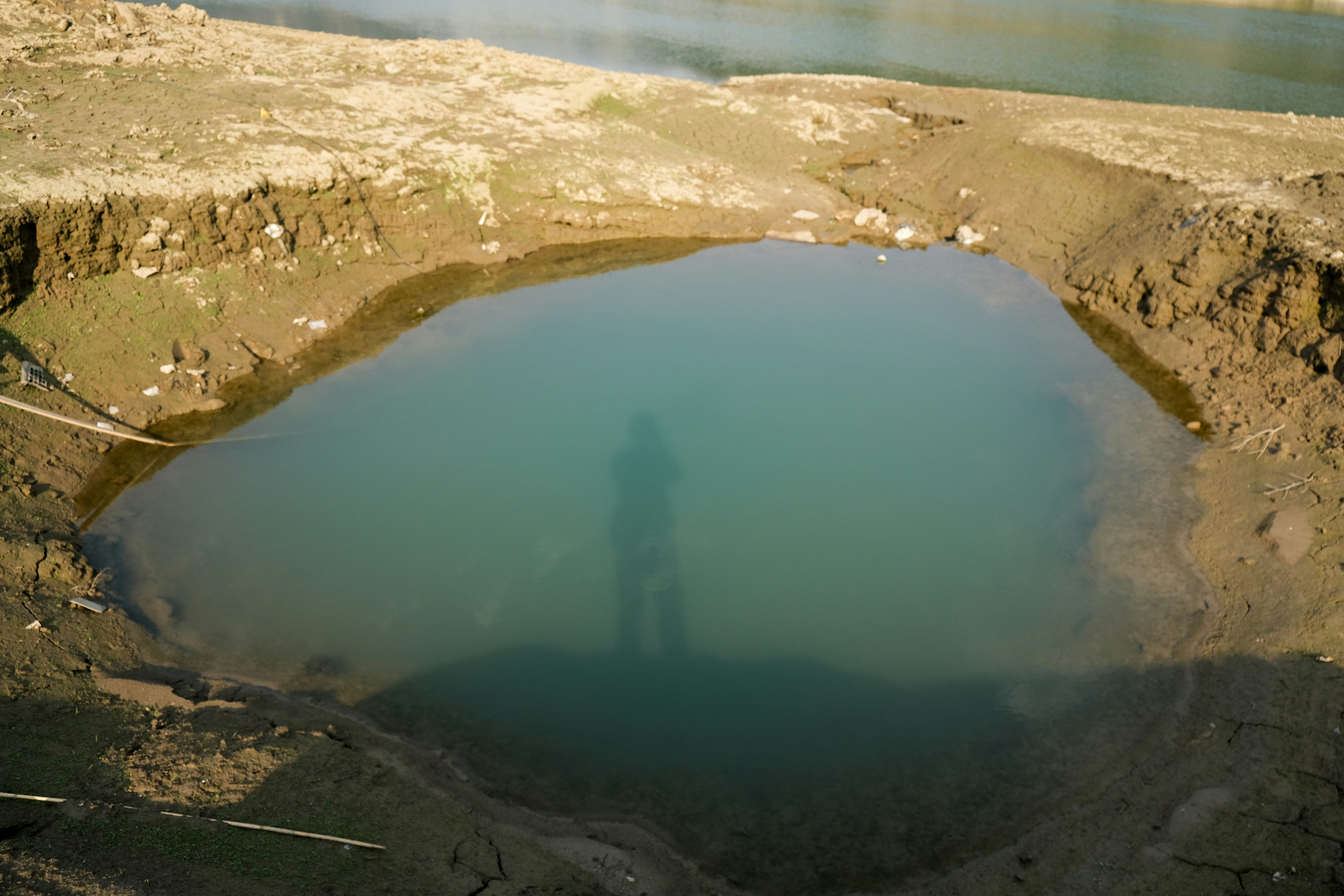 Shadow in the Quarried Pool: A Person Looms in Blue Stillness