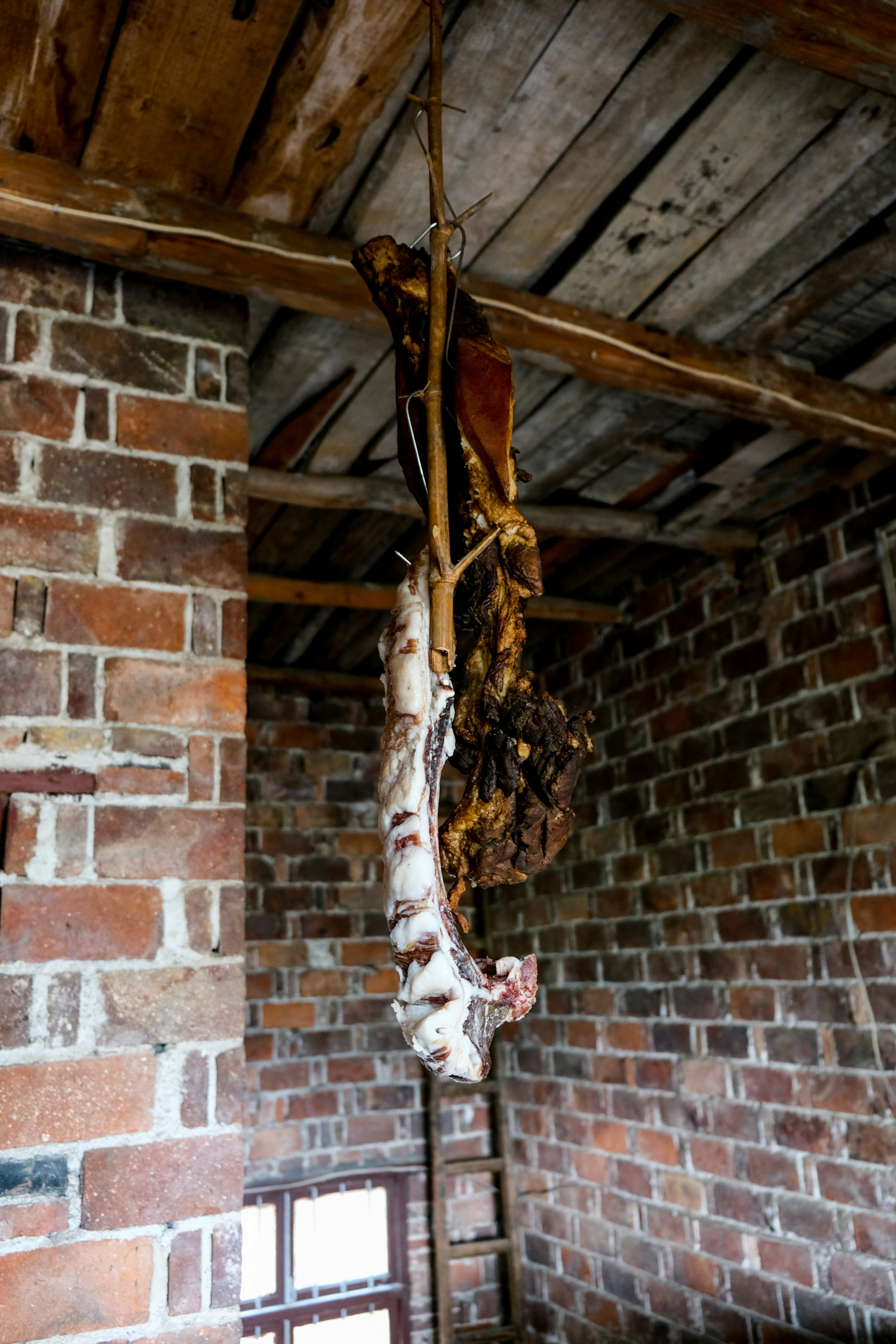 Hanging remains in a brick-walled workshop