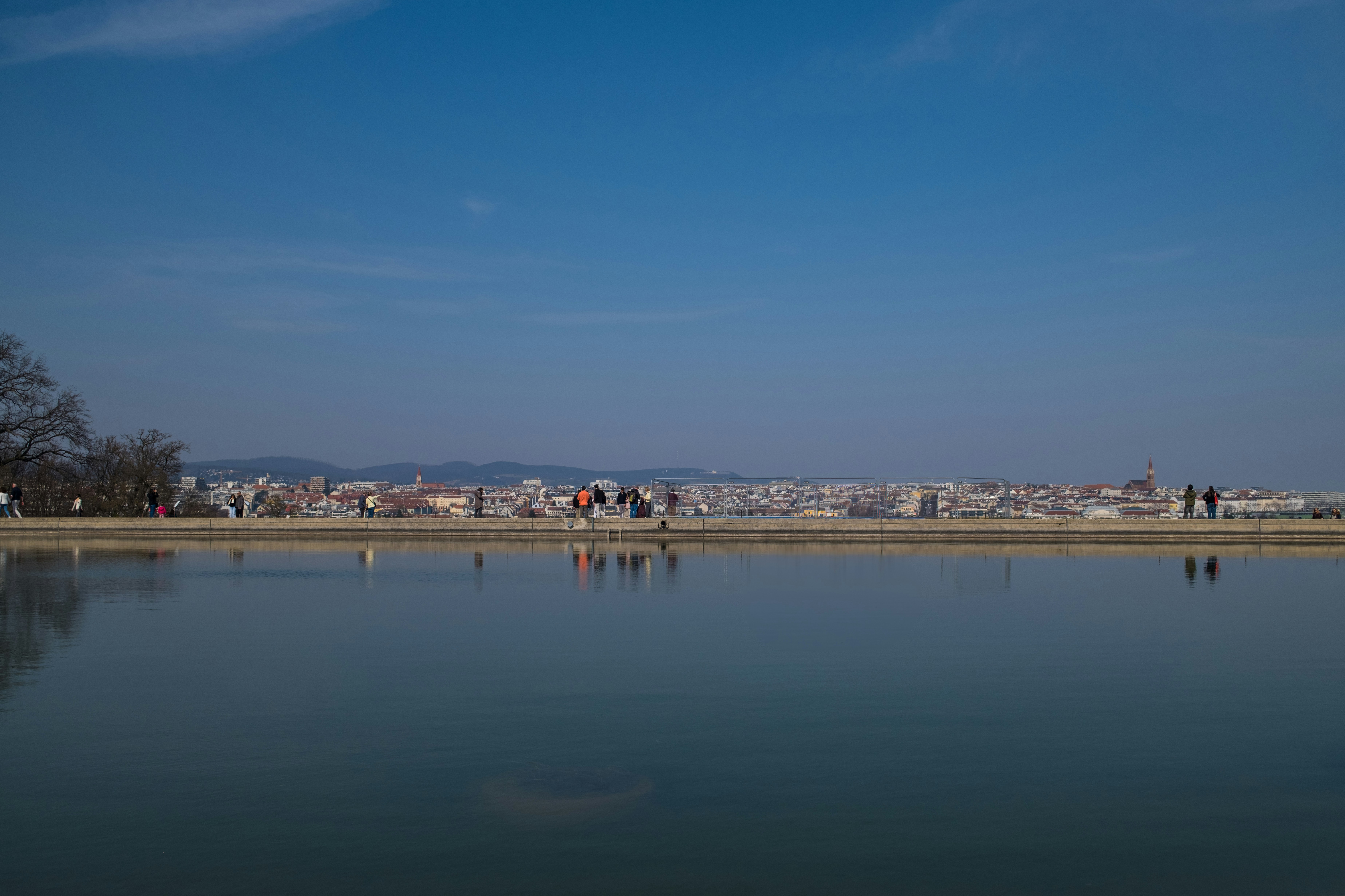 Quiet riverfront skyline under a calm blue sky