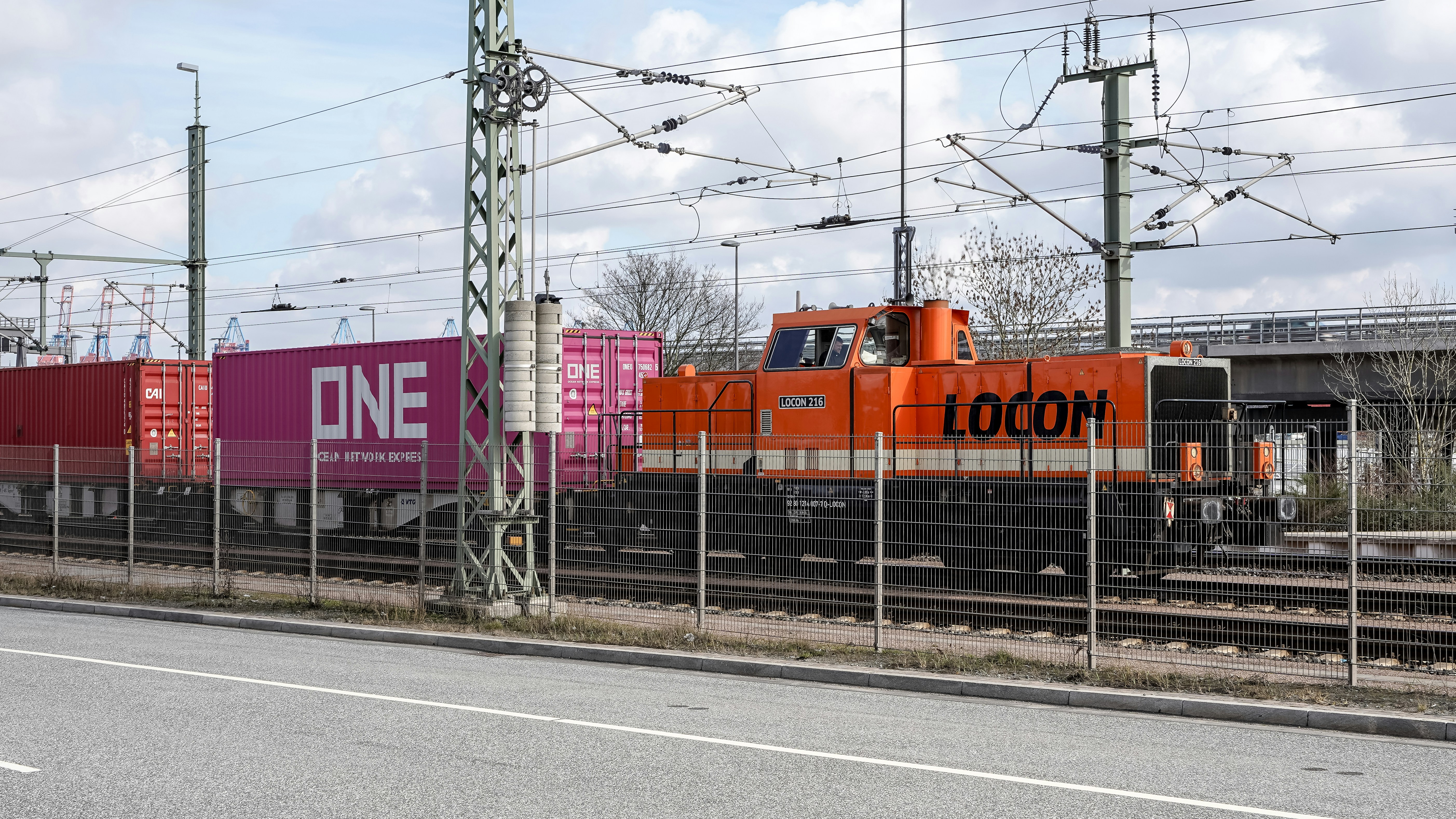Orange Locomotive on the Rails: Industrial Corridor