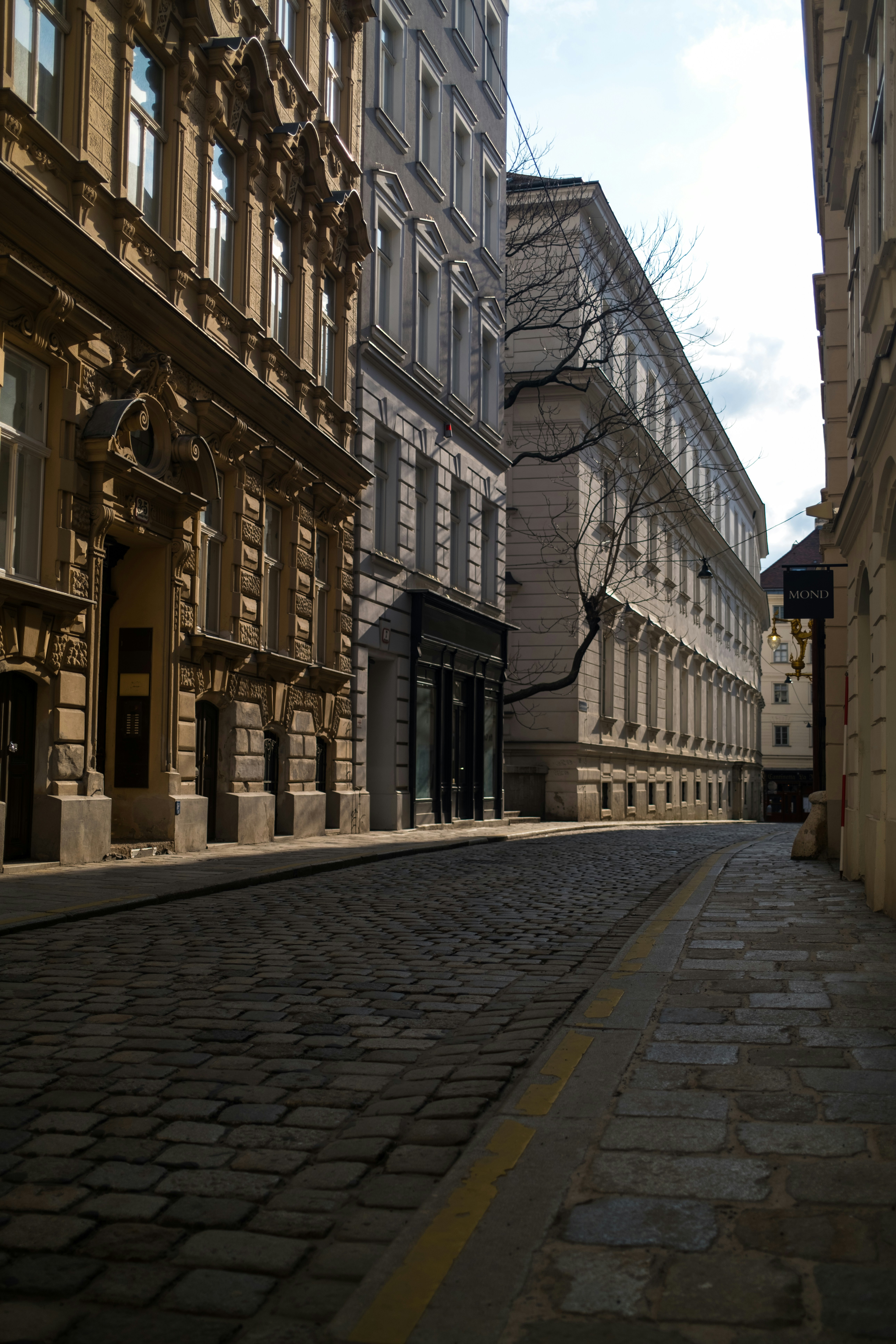 Cobbled Street Convergence: Facades and Light in a Quiet Urban Bend