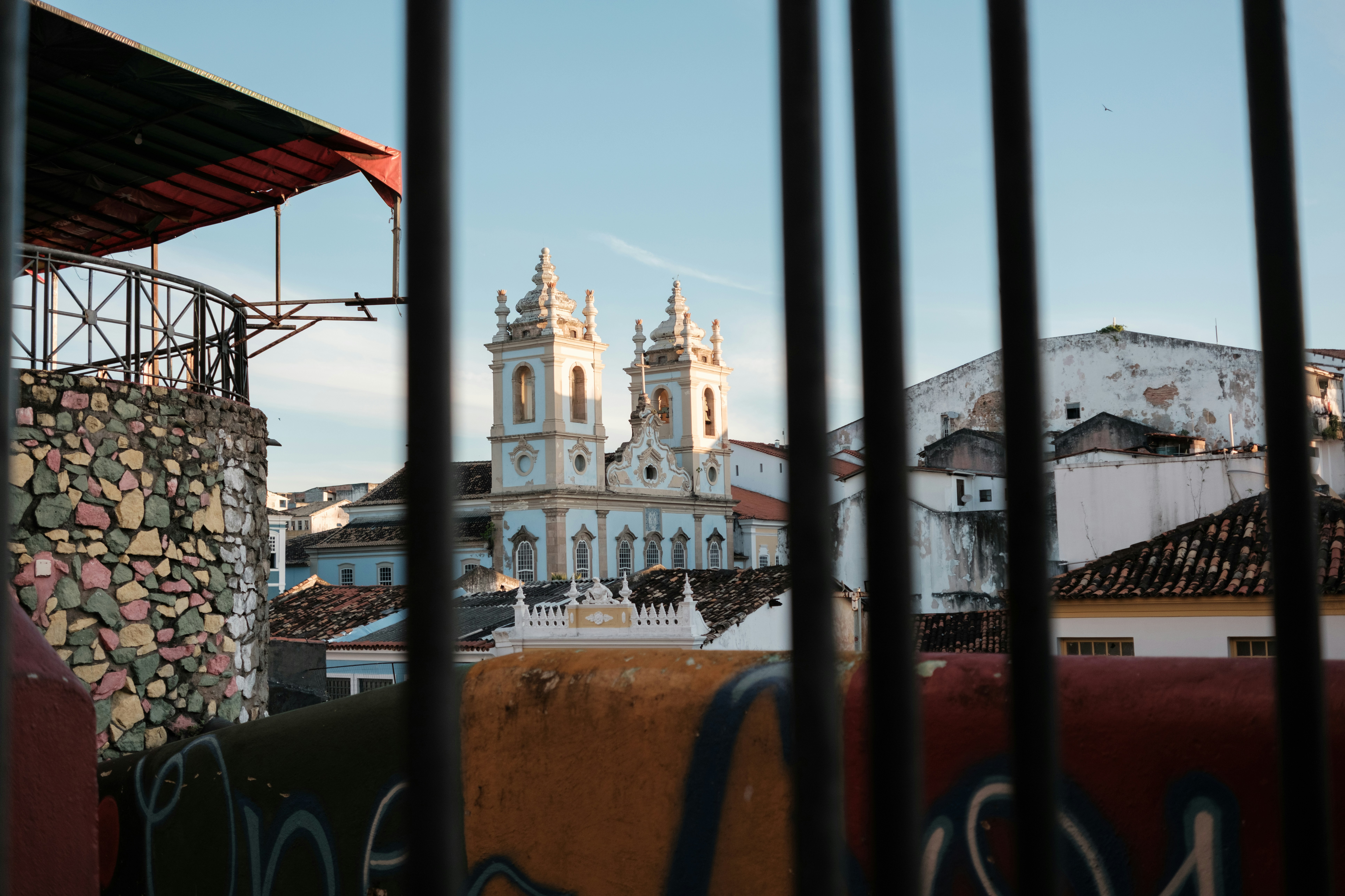 Blue Sky Over the City: Bars Framing a Cathedral Front