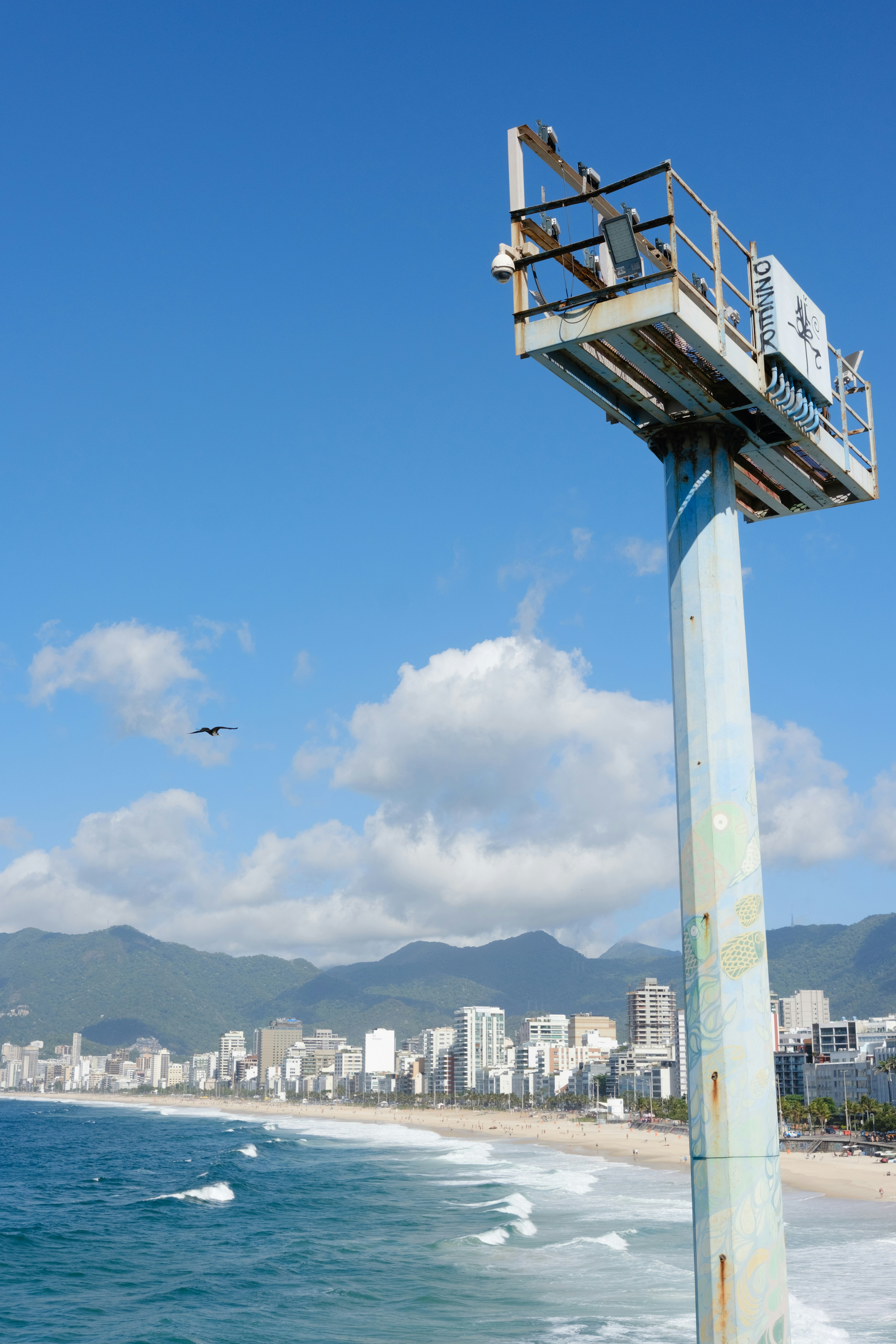 Coastal Elevator: A Crane Against a Coral Sky Over a Neon City