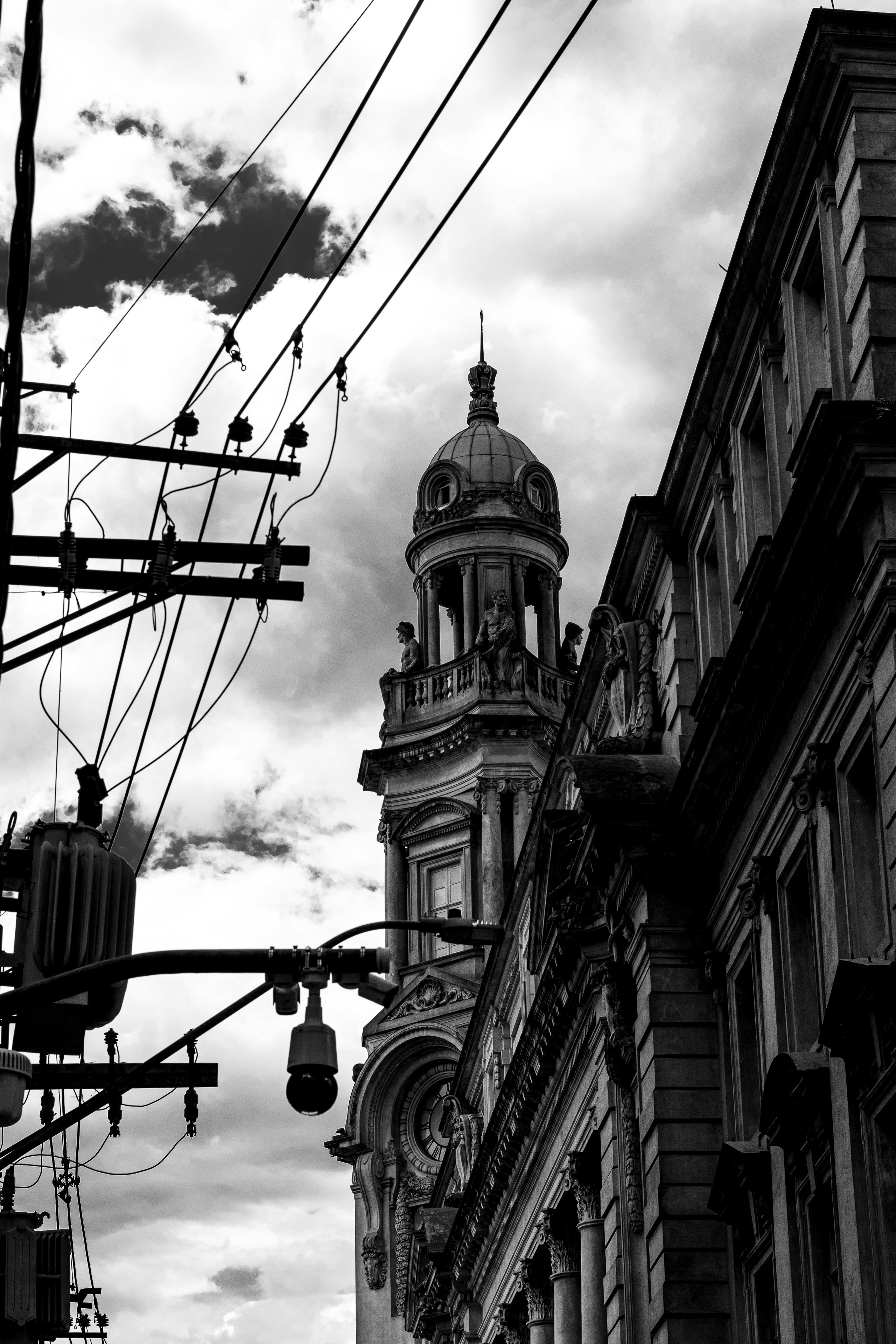 Urban Clocktower Silhouette: Archs and Wires under Clouded Sky