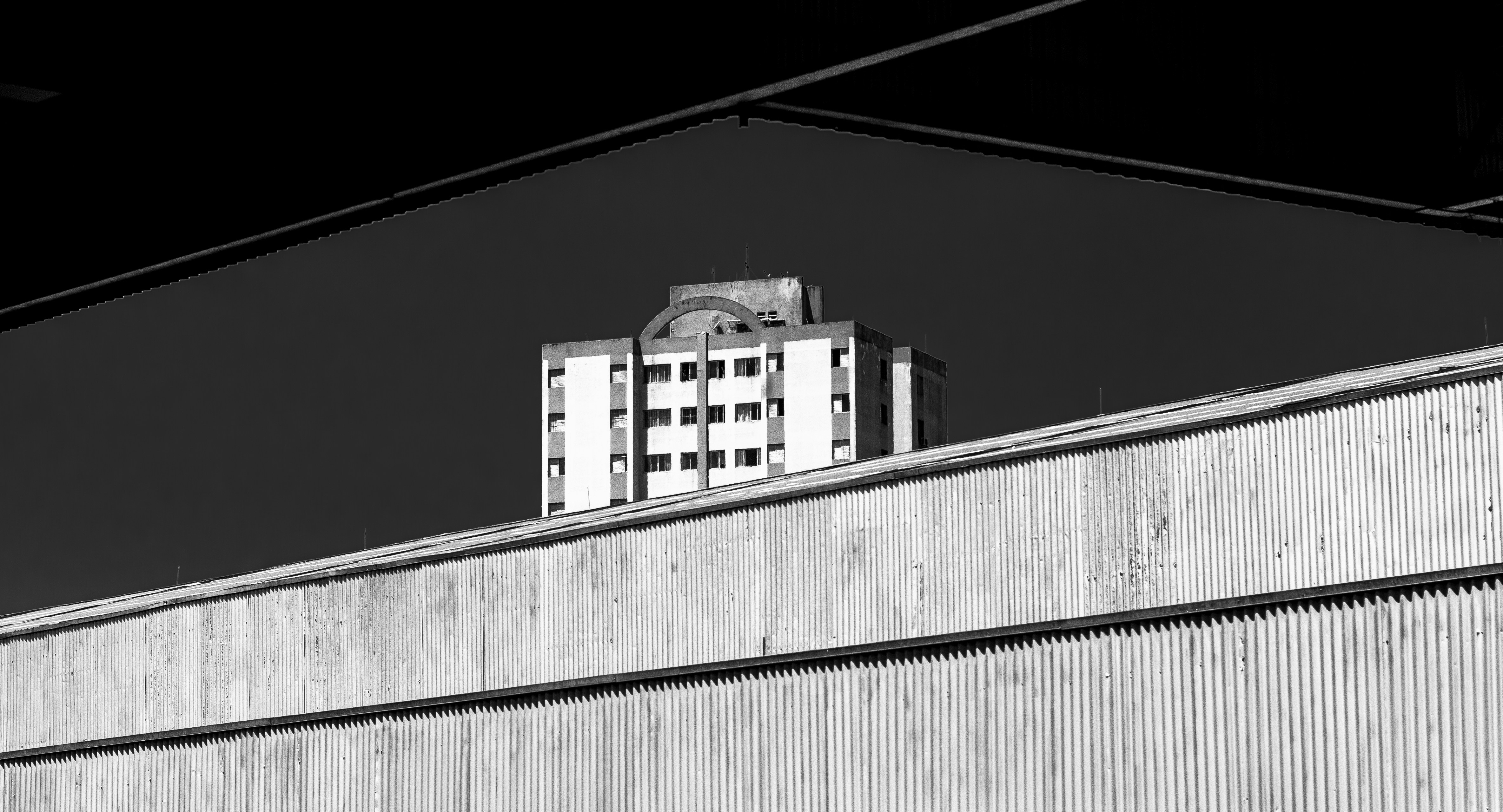 Concrete skyline: a solitary tower peeking over corrugated edges
