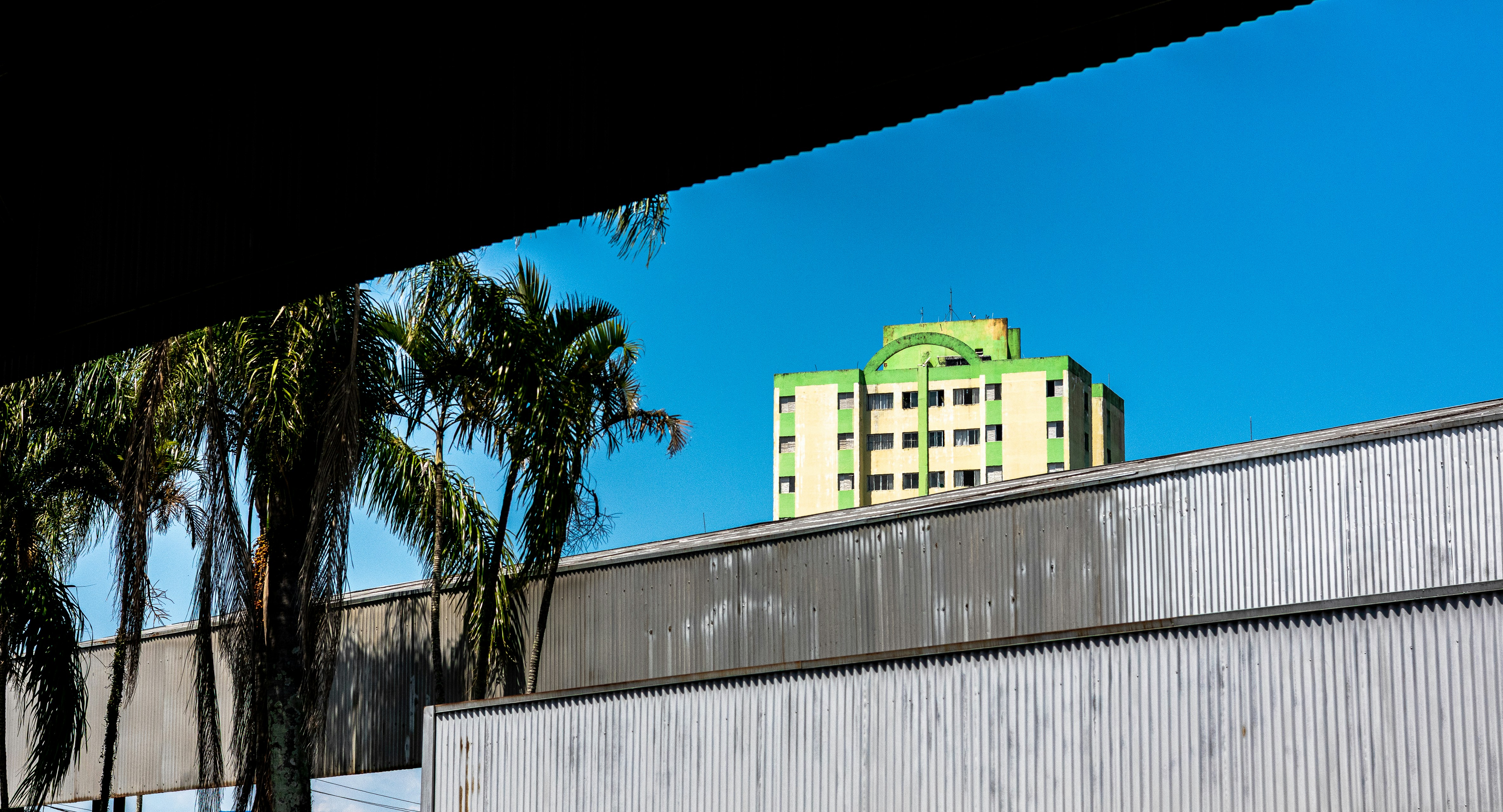 Green-Topped Tower Rising Over Industrial Grays