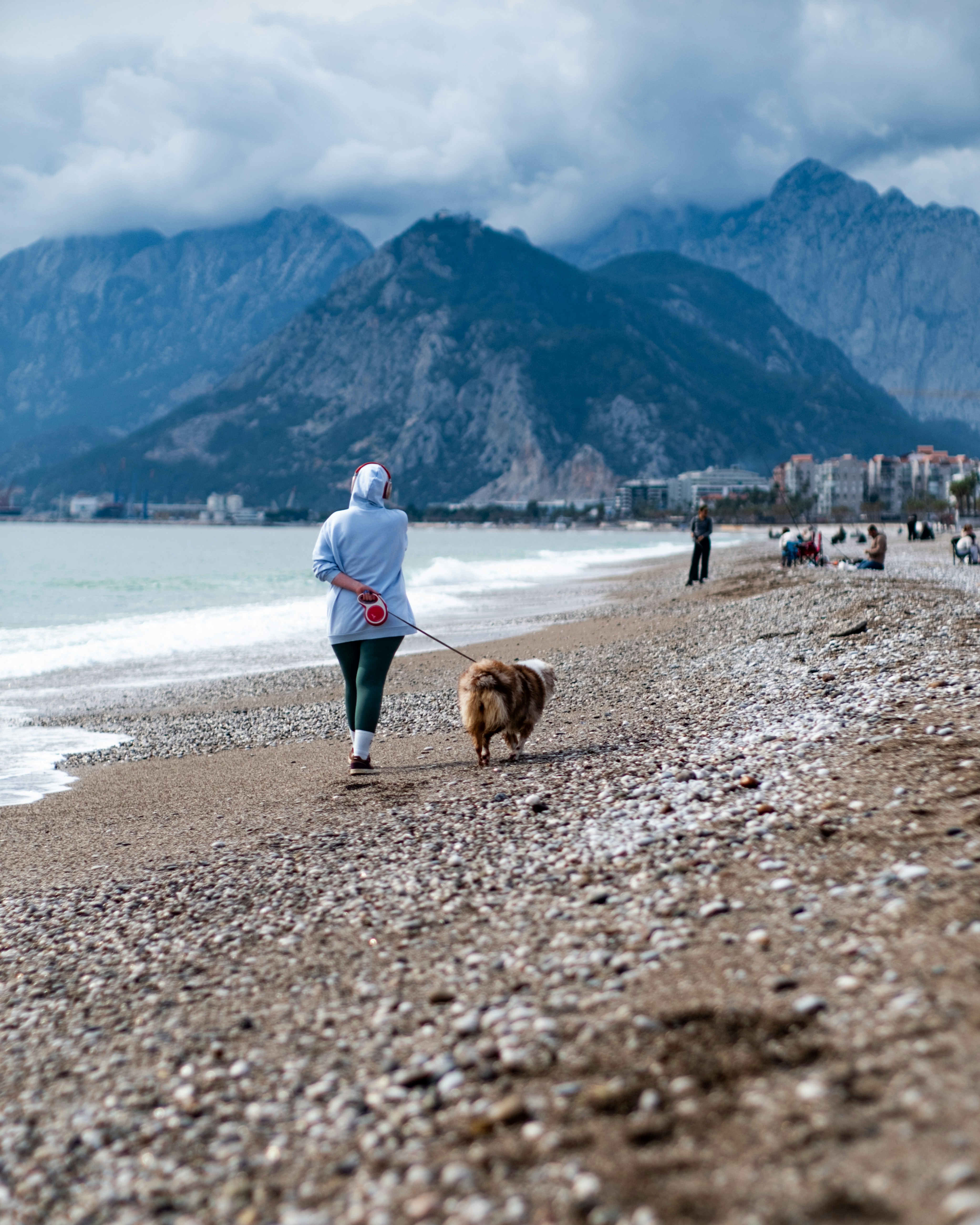 Stroll with a companion along a pebbled Adriatic shore beneath looming peaks