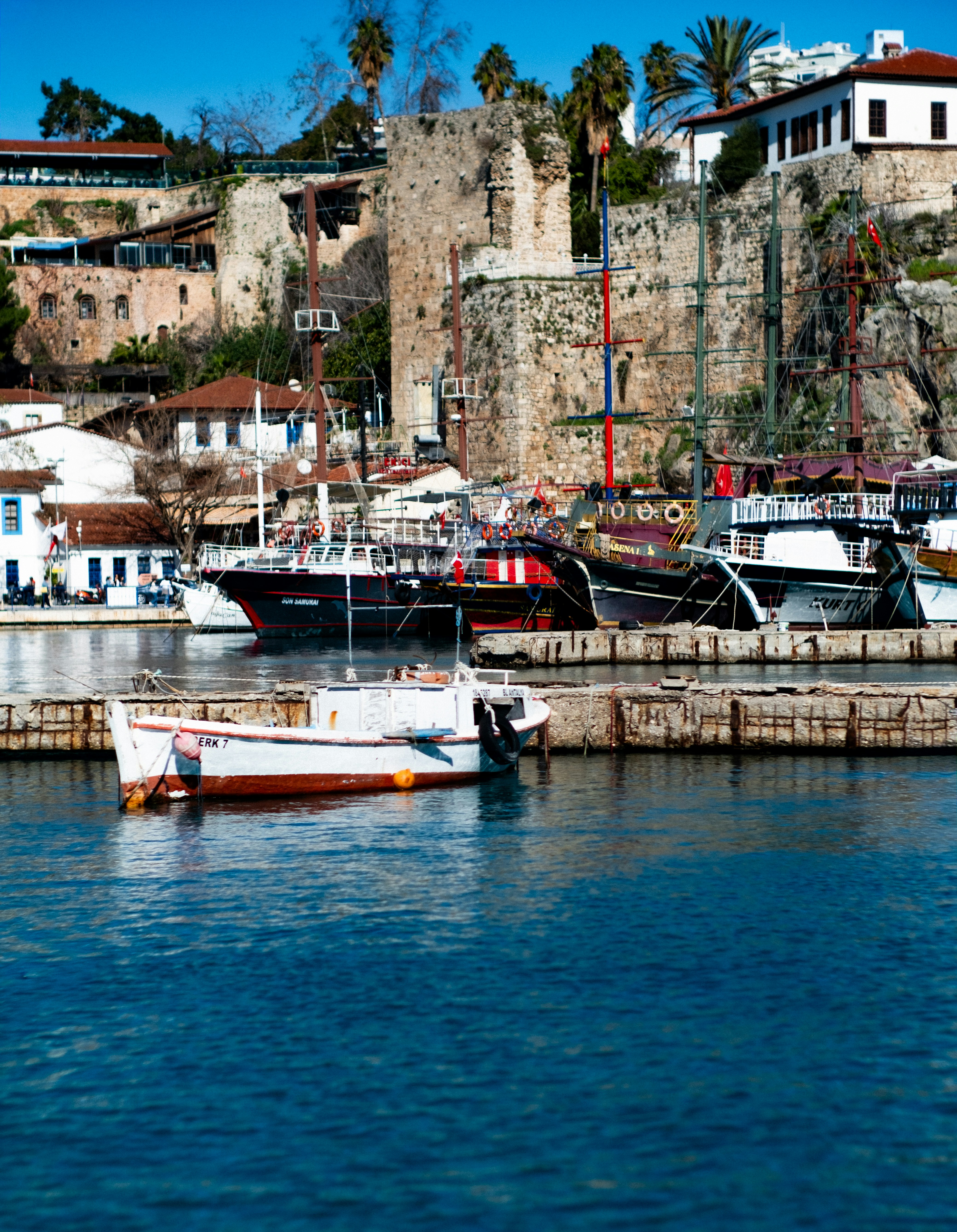 Harbor of Time: Boats and Stone Walls Under a Mediterranean Sky