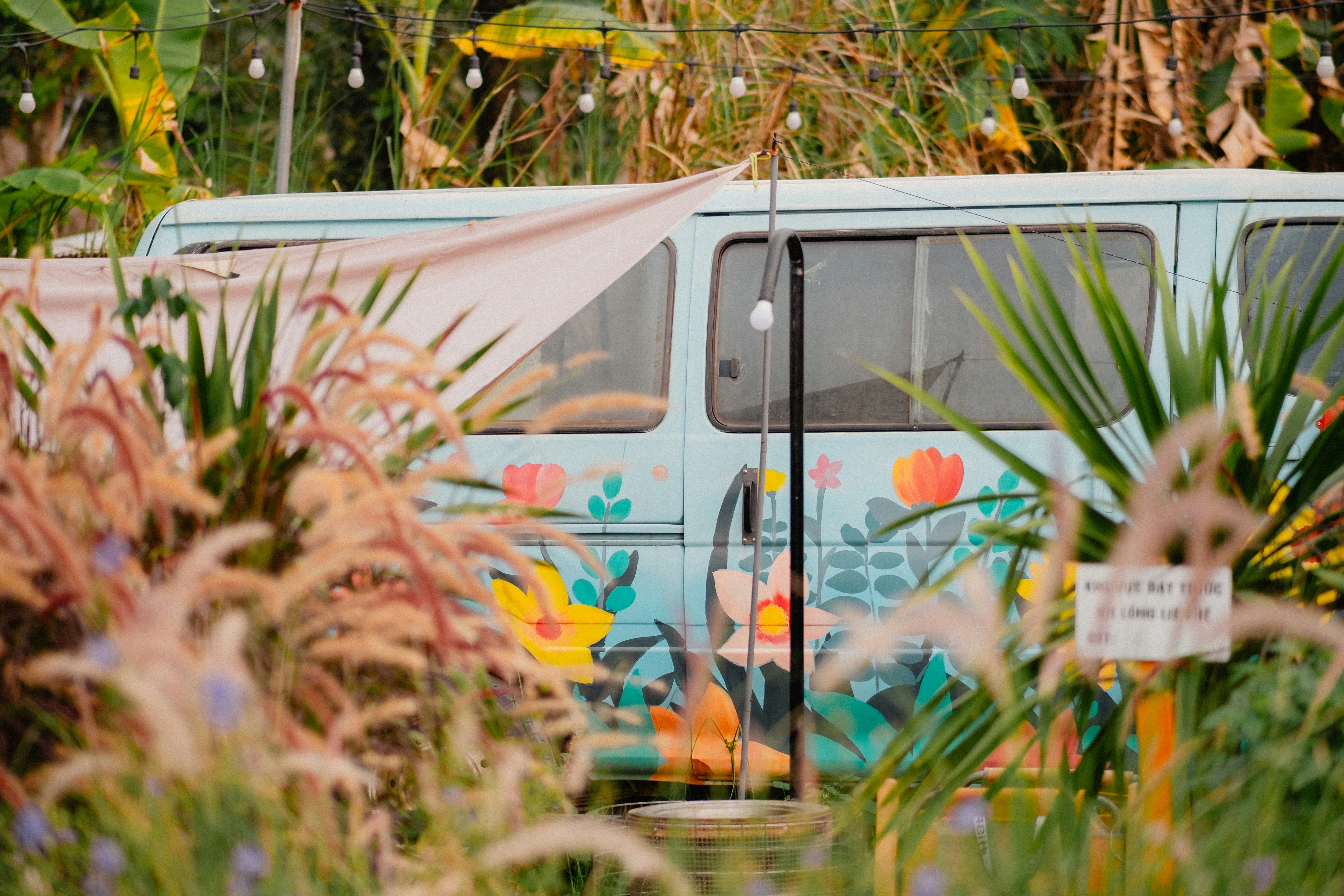 Floral mural van grounded in a leafy foreground garden
