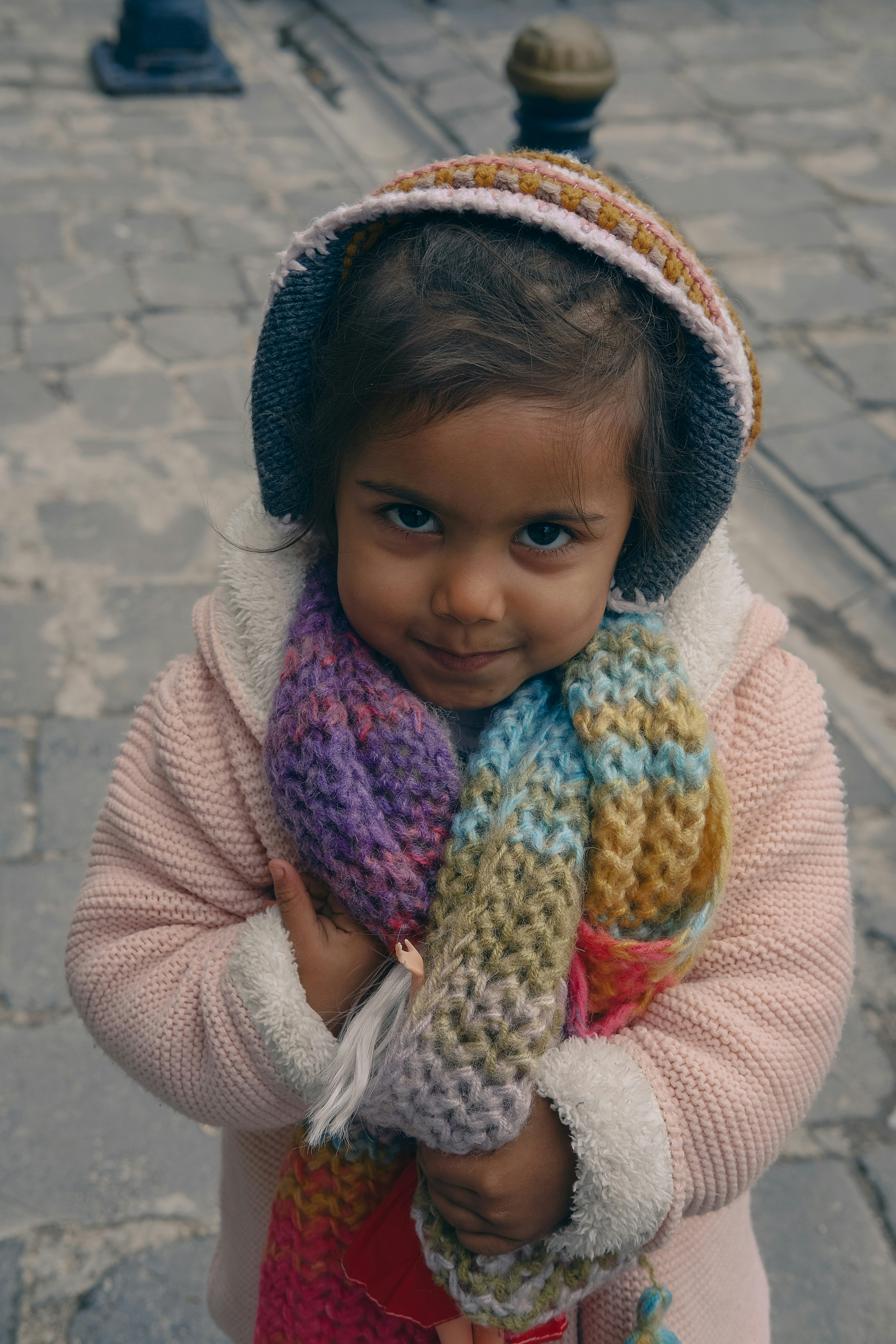 Sunlit Smile: A Child Wrapped in Colorful Winter Threads
