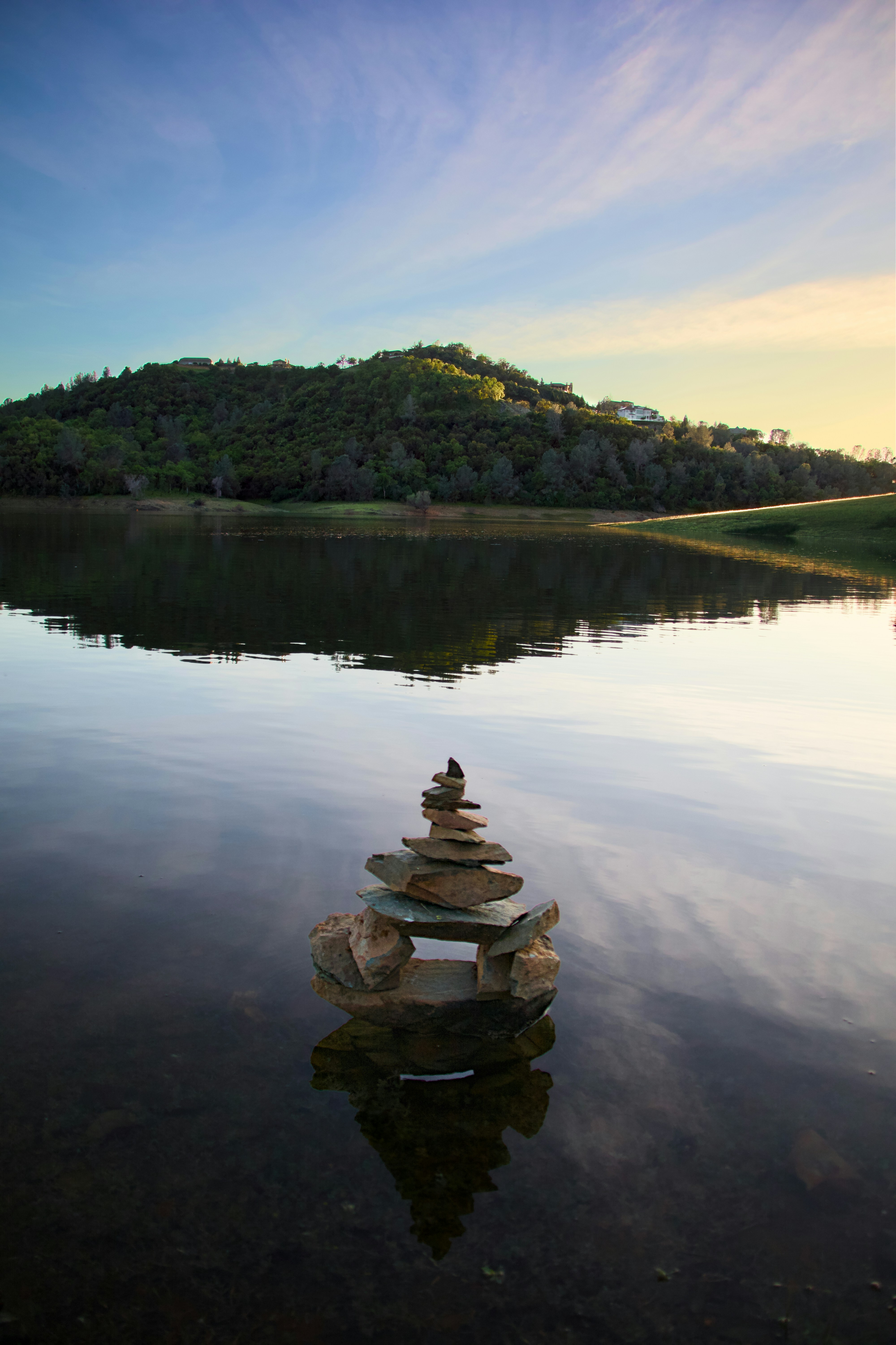 Stone Stack at Sunset: Balance on a Tranquil Lake