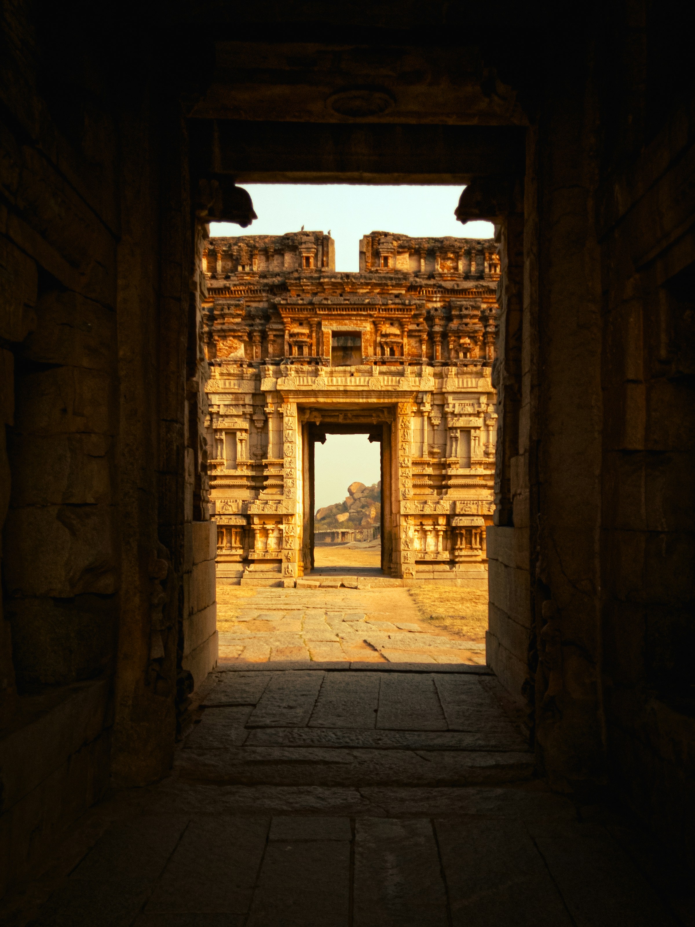 Gateway to the Sunlit Courtyard: Carved Portal Framing the Distant Hall