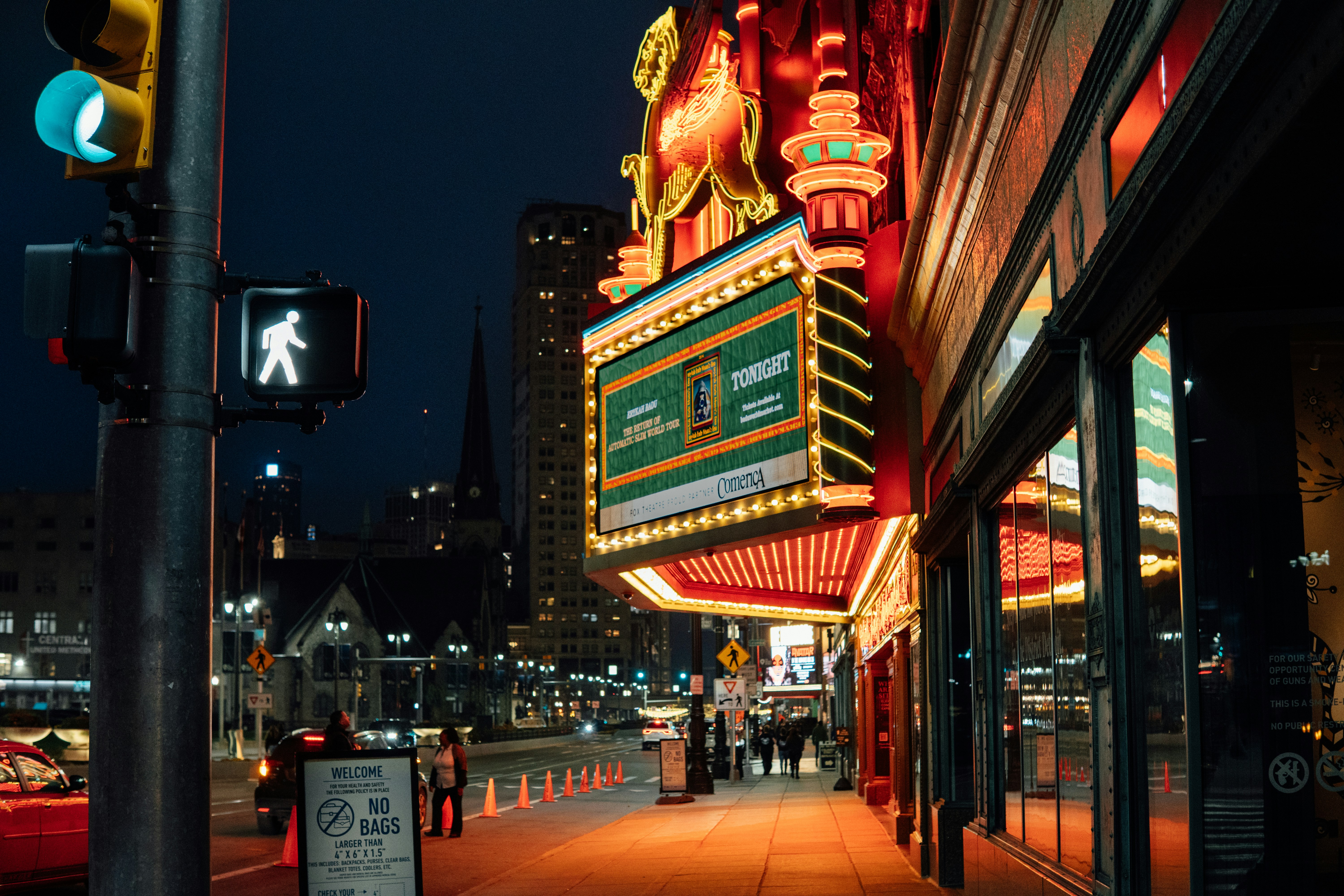 Neon marquee of a cinema strip glow over a quiet urban night