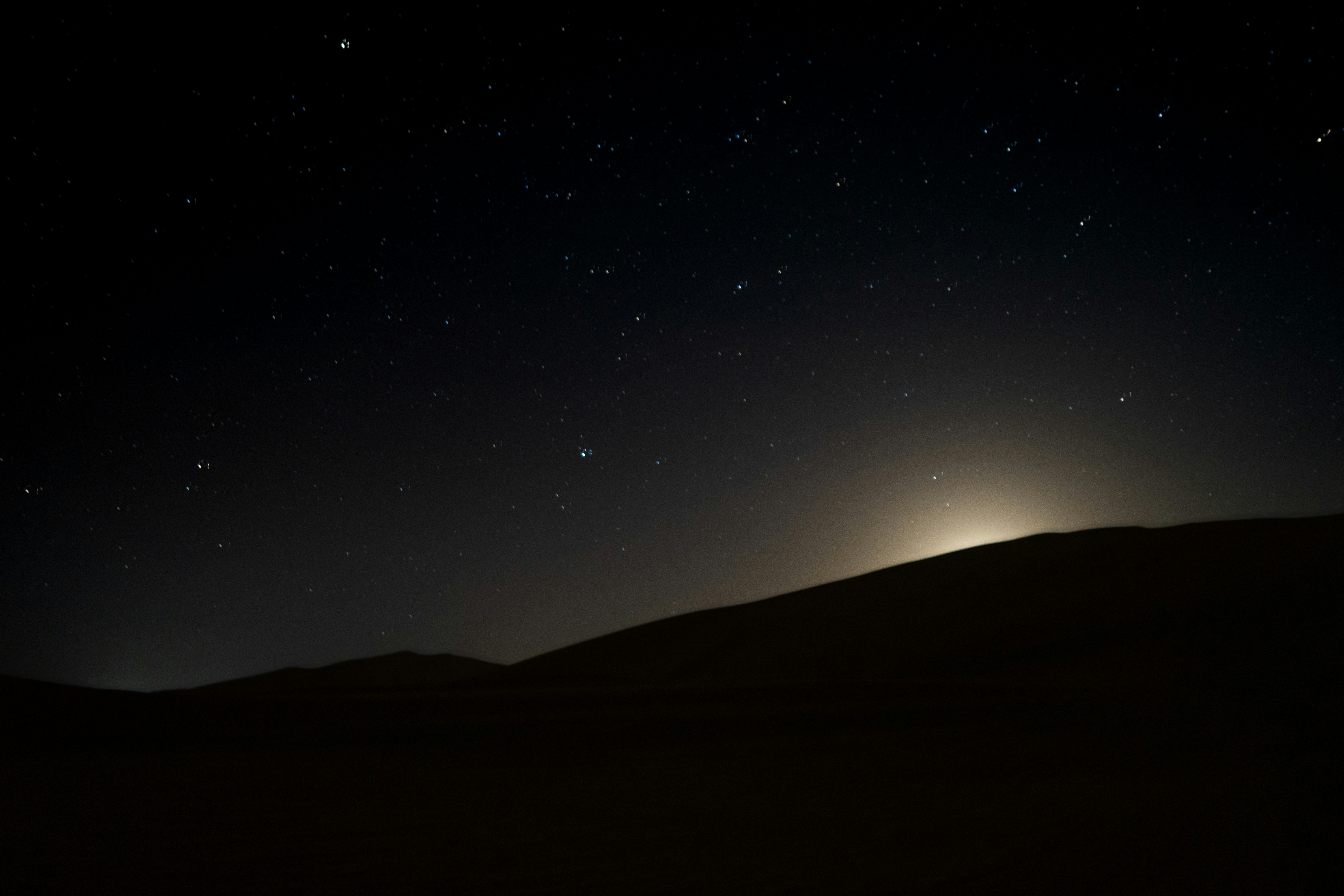 Dawn on the Dunes: Stars Rise Behind a Quiet Ridge