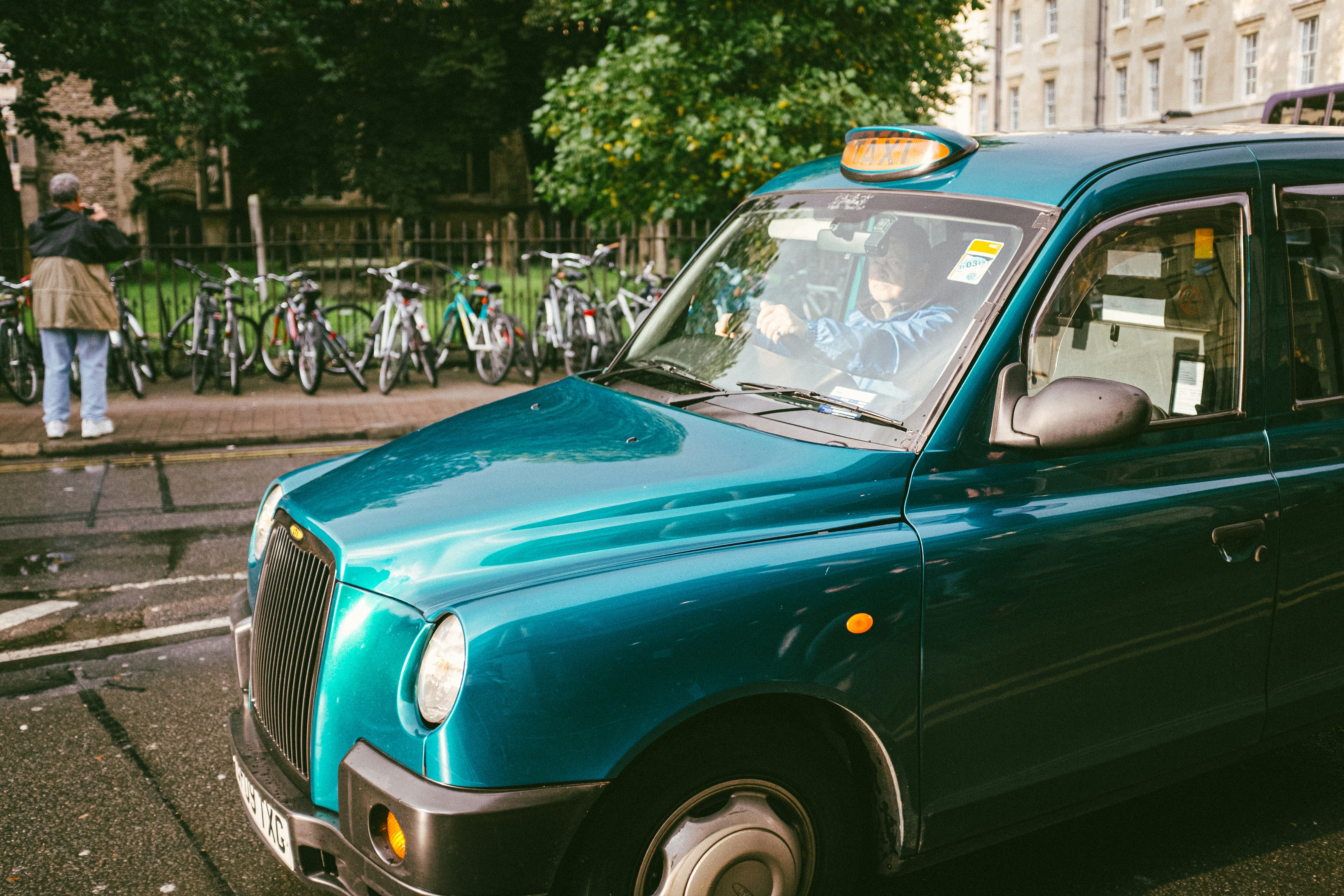 Teal Taxi at the Edge of a City Street