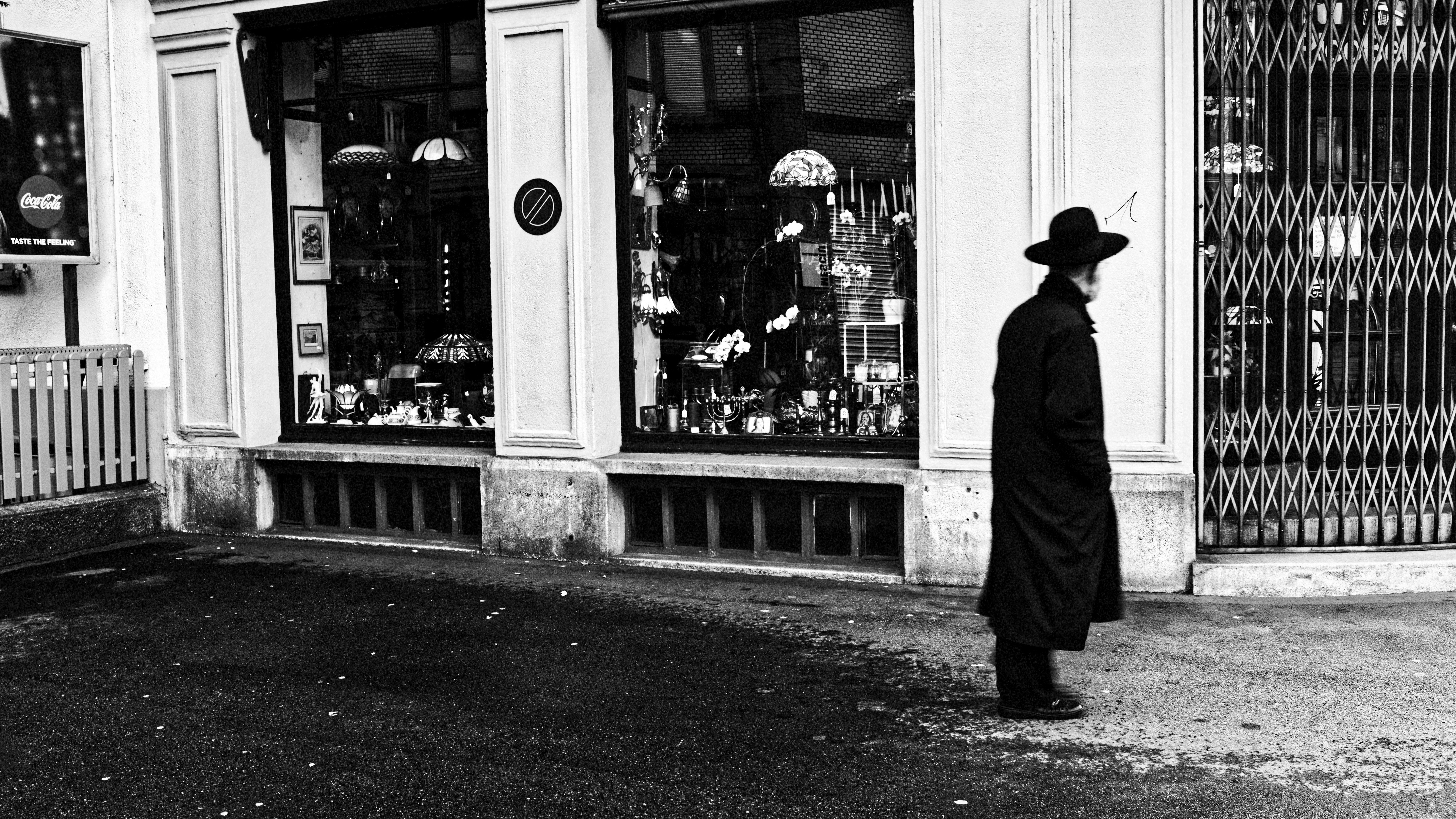 Shadows in Transit: A Figure Passes the Shopfront