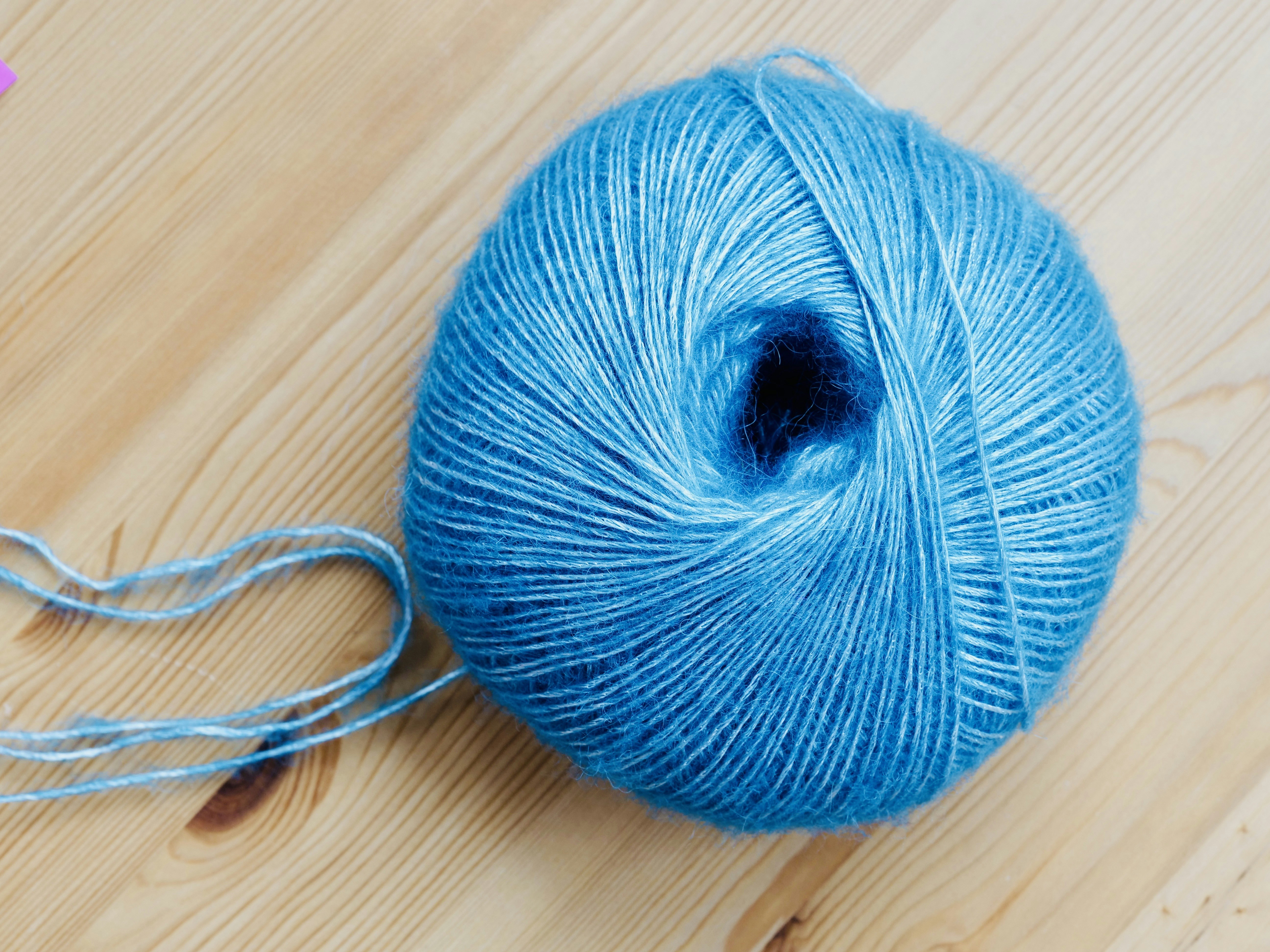 Blue Yarn Sphere on Light Wood Surface