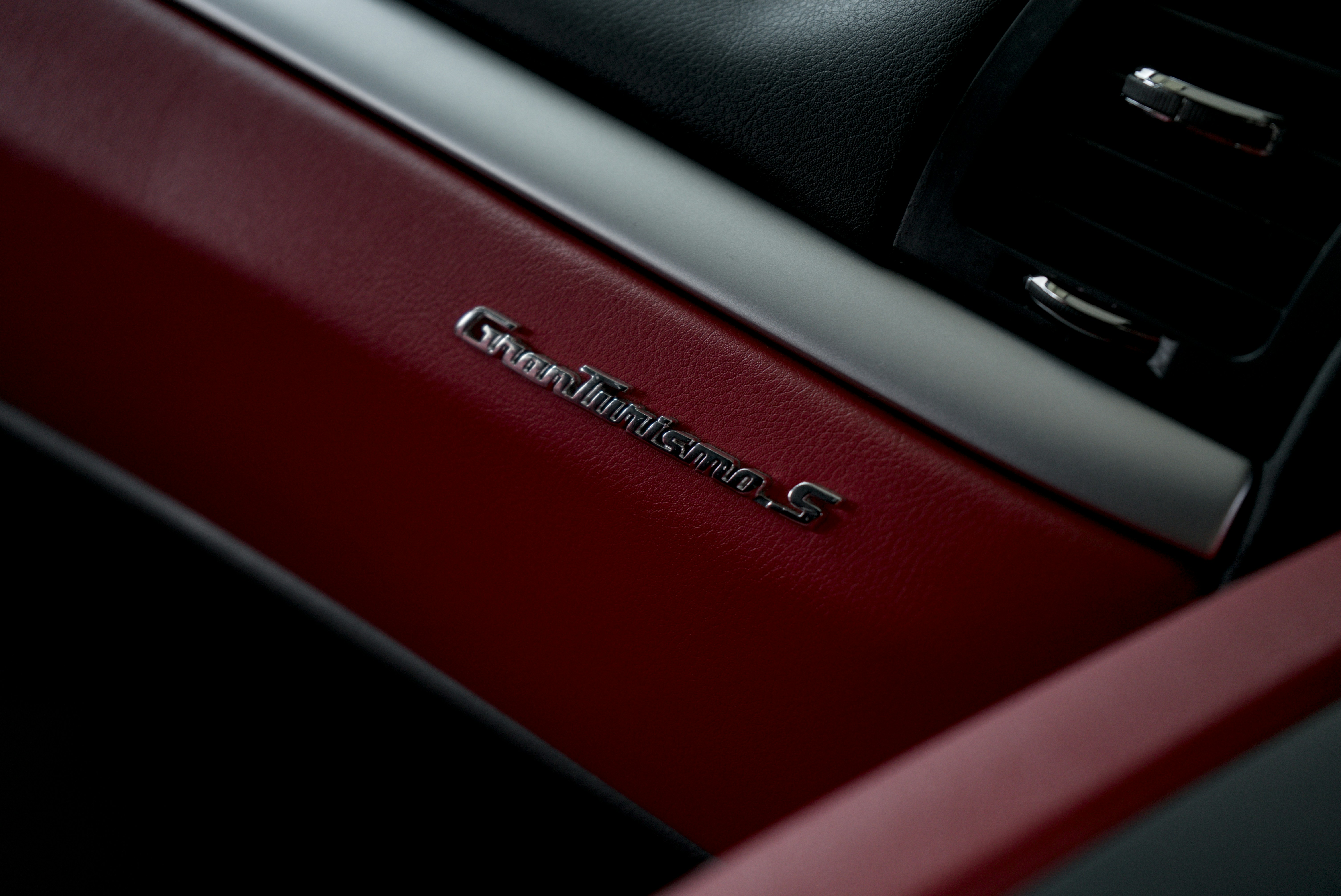 Red Center Console Badge: Maserati-esque Script on Rich Burgundy Leather