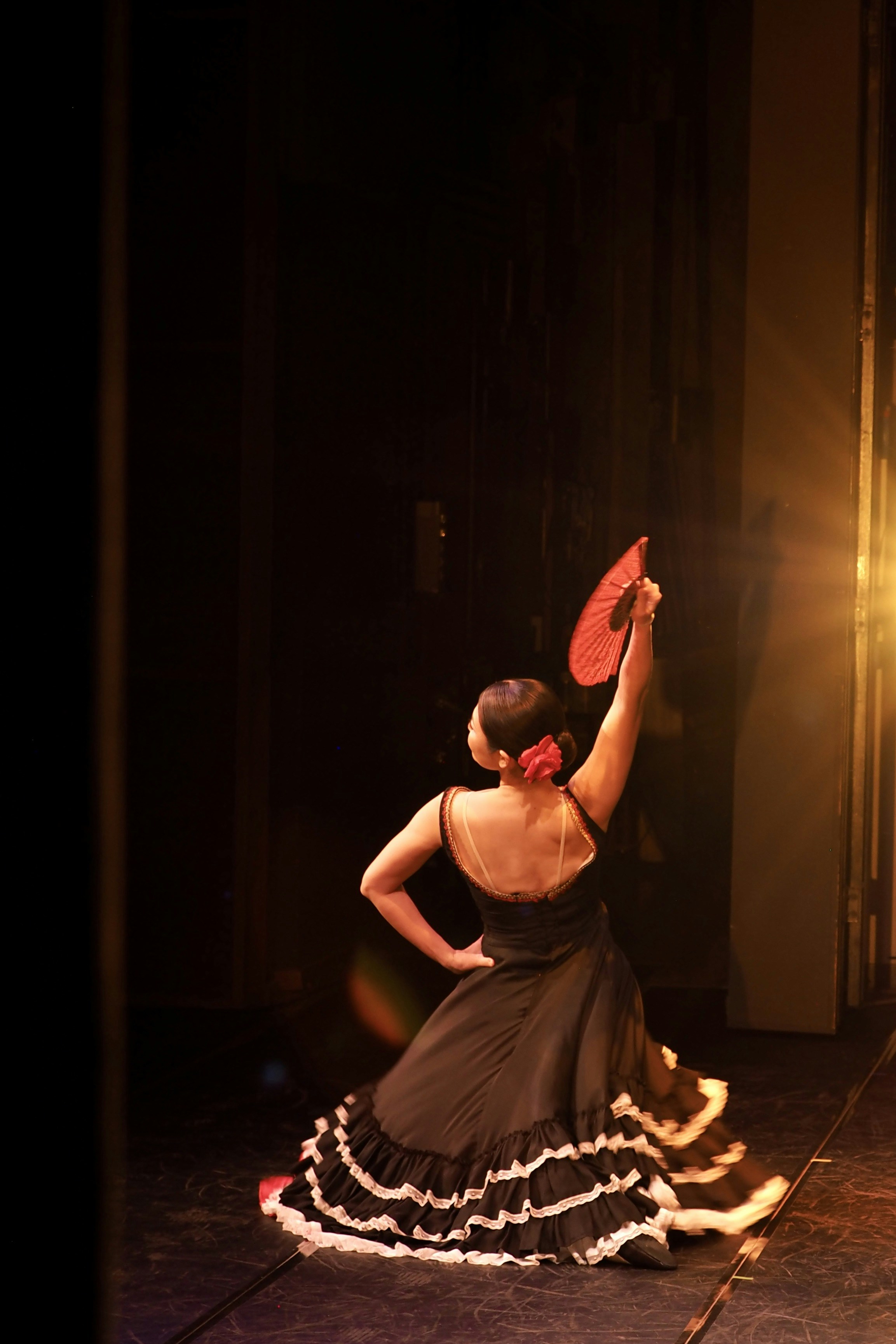 Red Fan and Velvet Dress: a Dancer in Golden Backstage Light