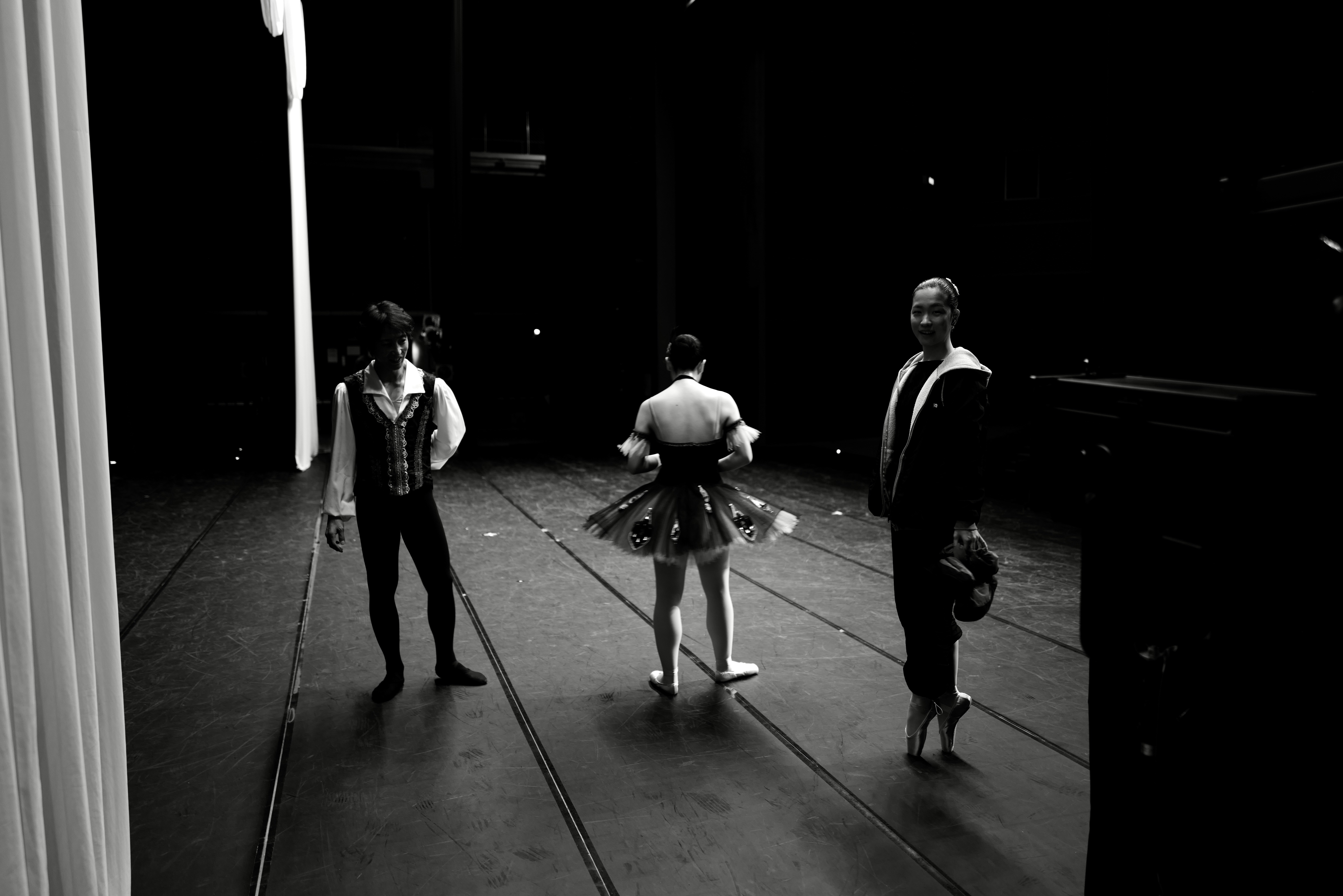 Backstage Quiet: Dancers Await in Dim Limelight