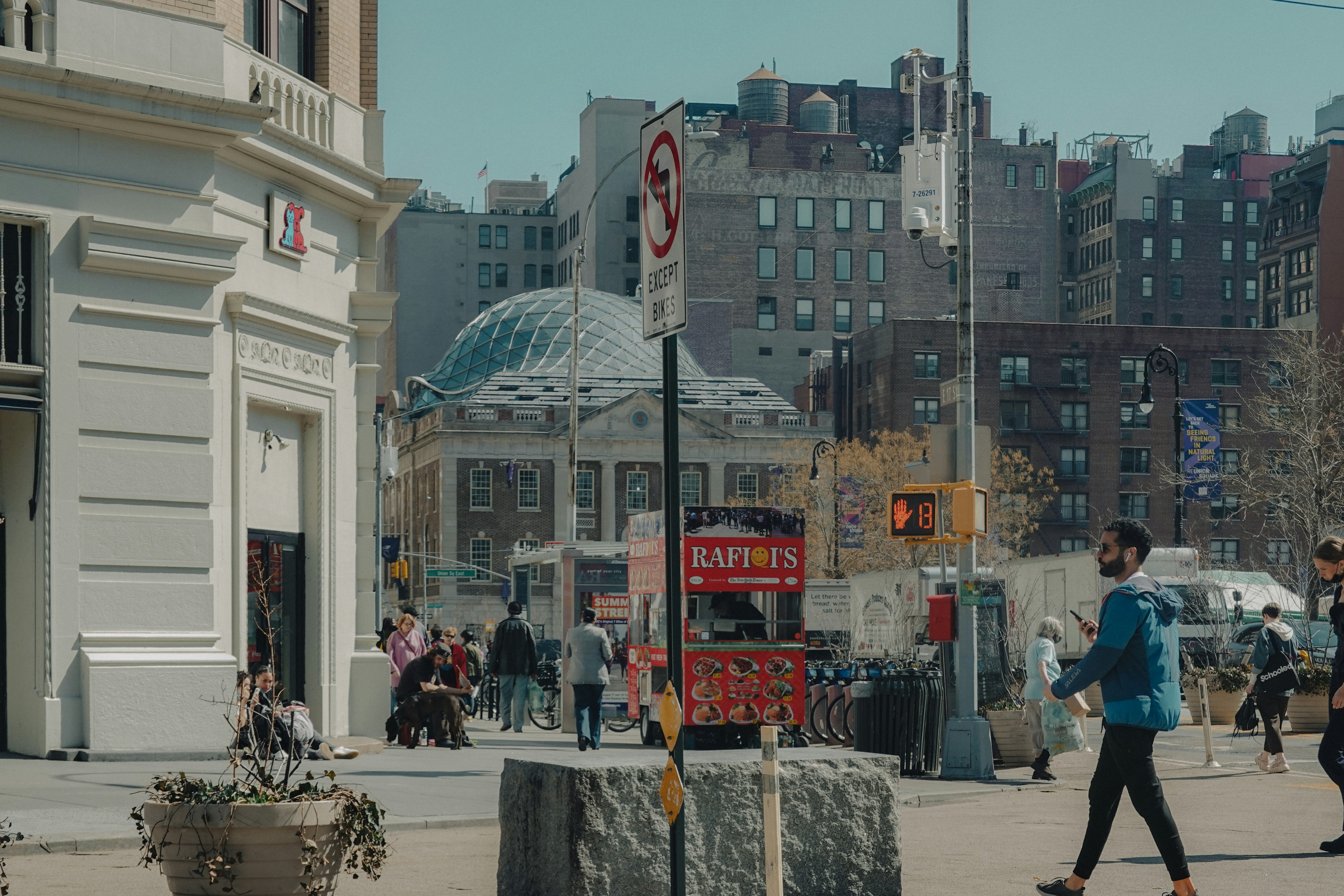 City Square Pause: People, Signage, and a Red Snack Cart