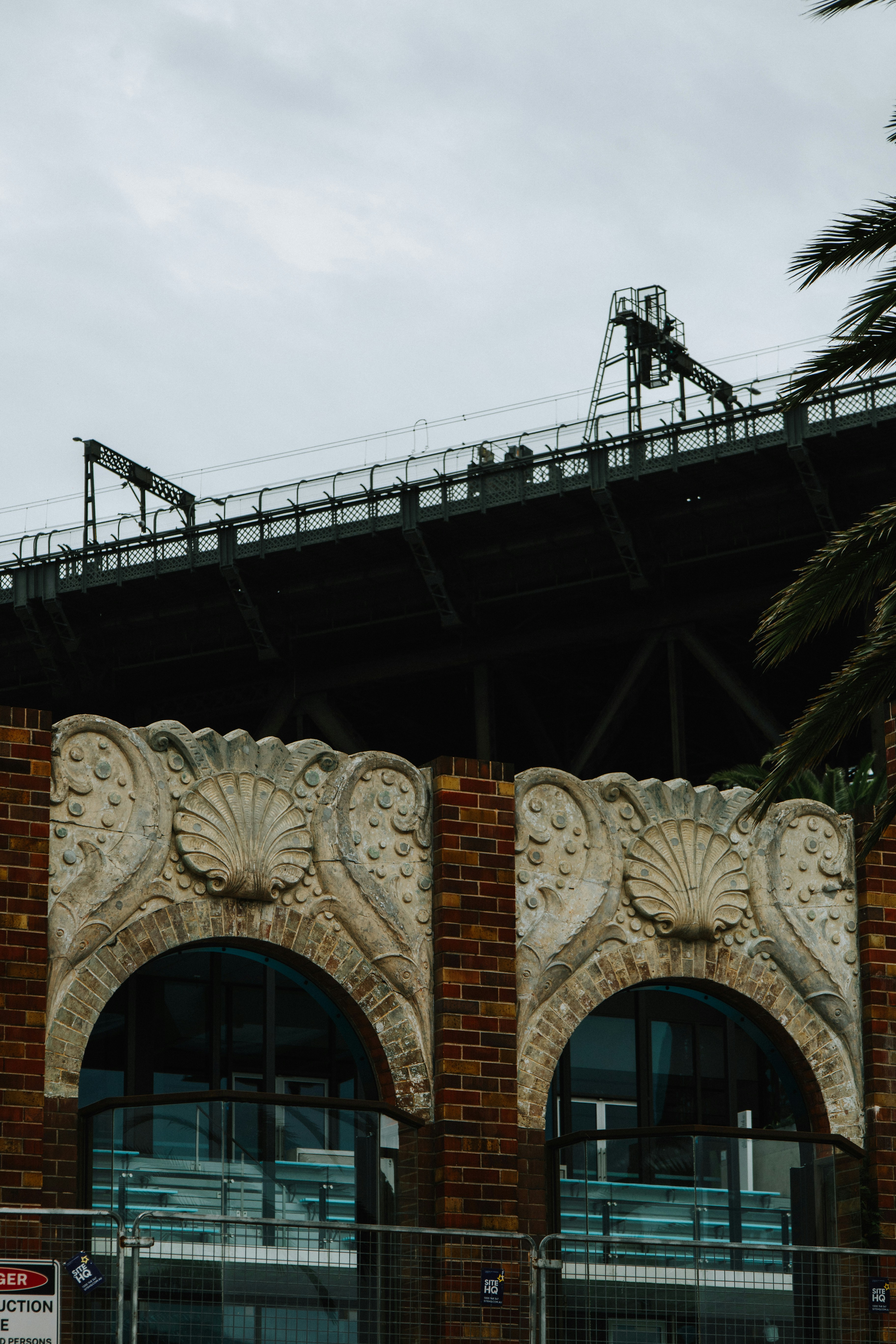 Bridged Facade: Carved Archways Against Industrial Span