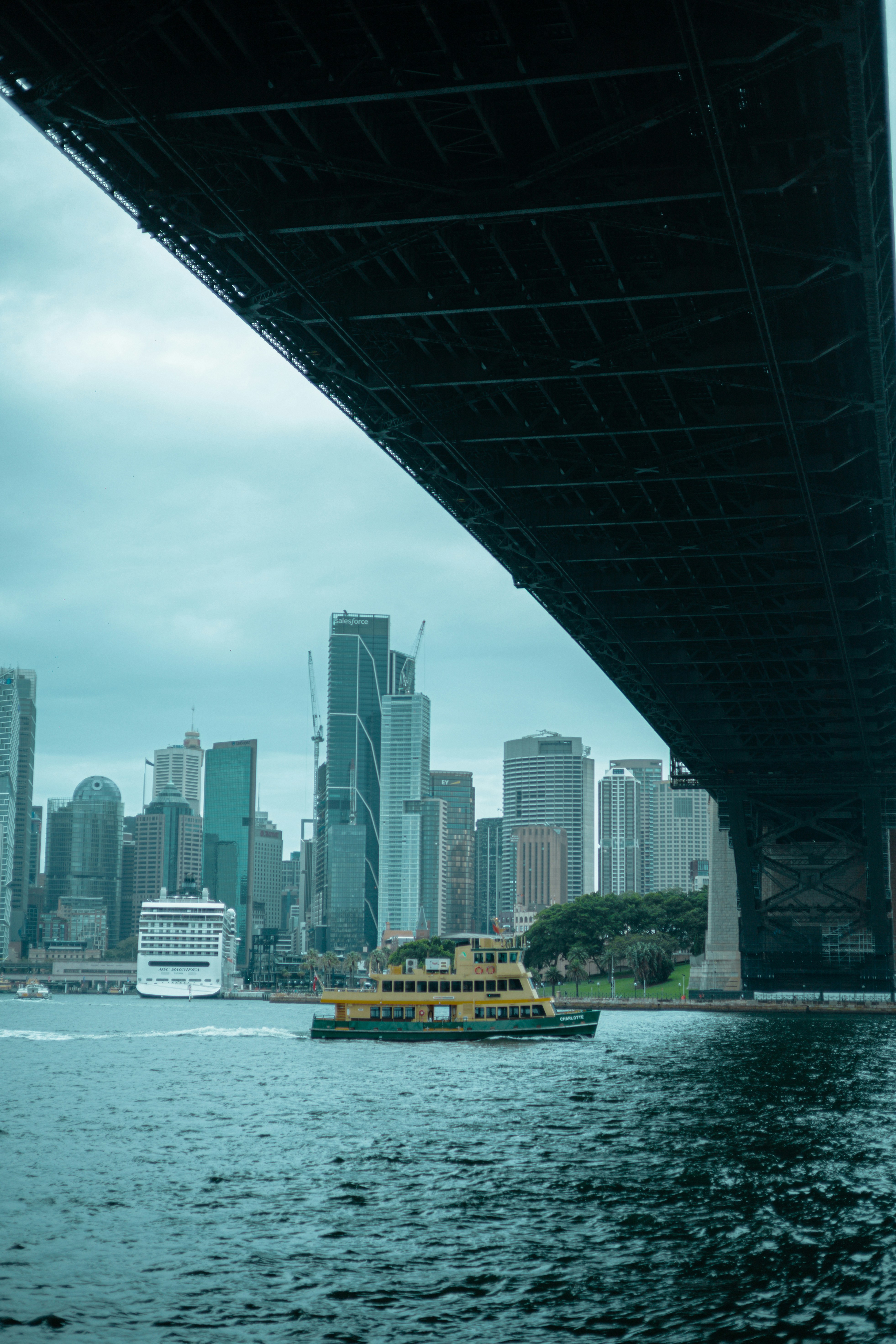 Under the Steel Span: City Boats gliding beneath a Massive Bridge