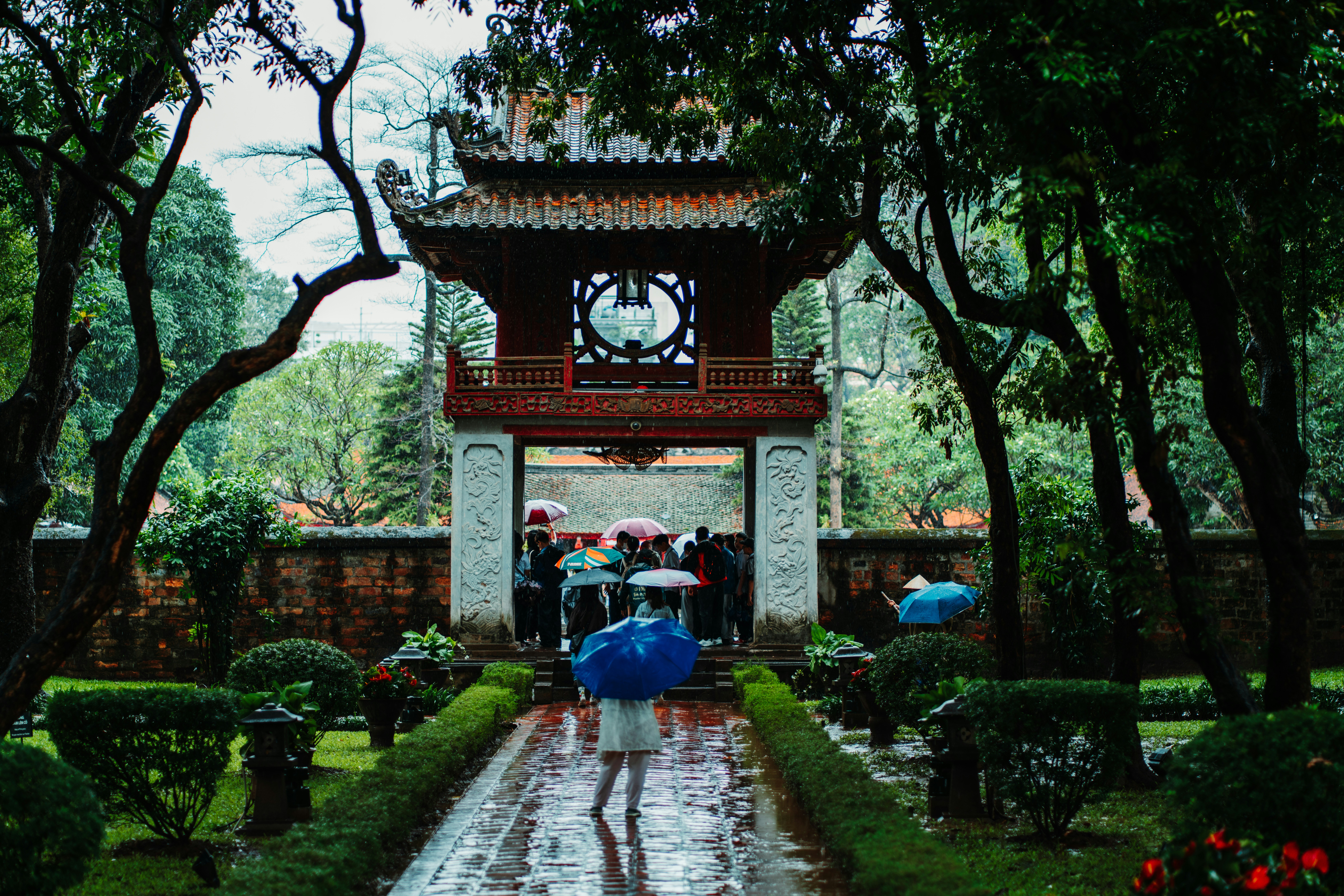 Blue Umbrella Crossing Under the Heritage Gate