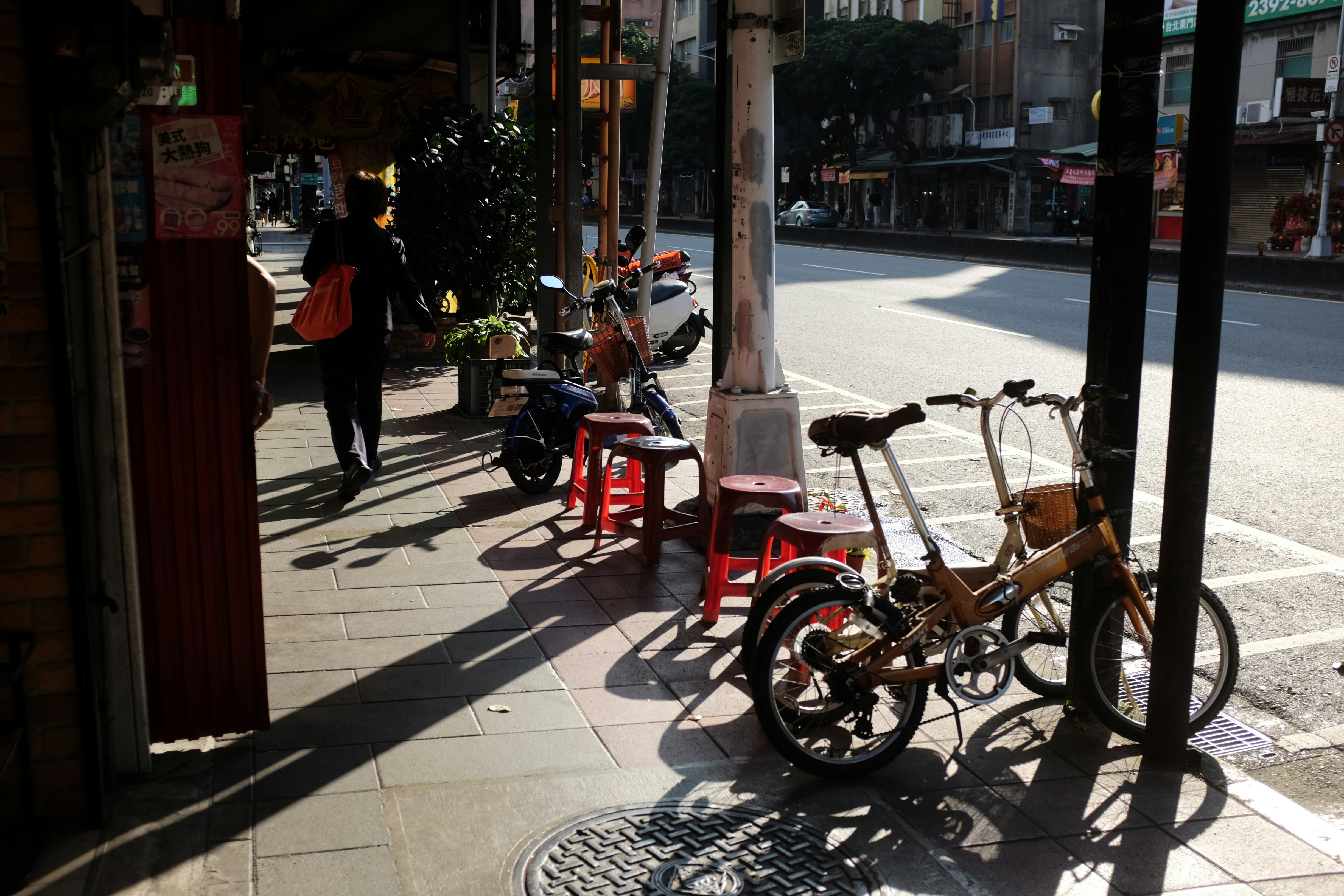 Sunlit Street Corner with bicycles and a lone passerby