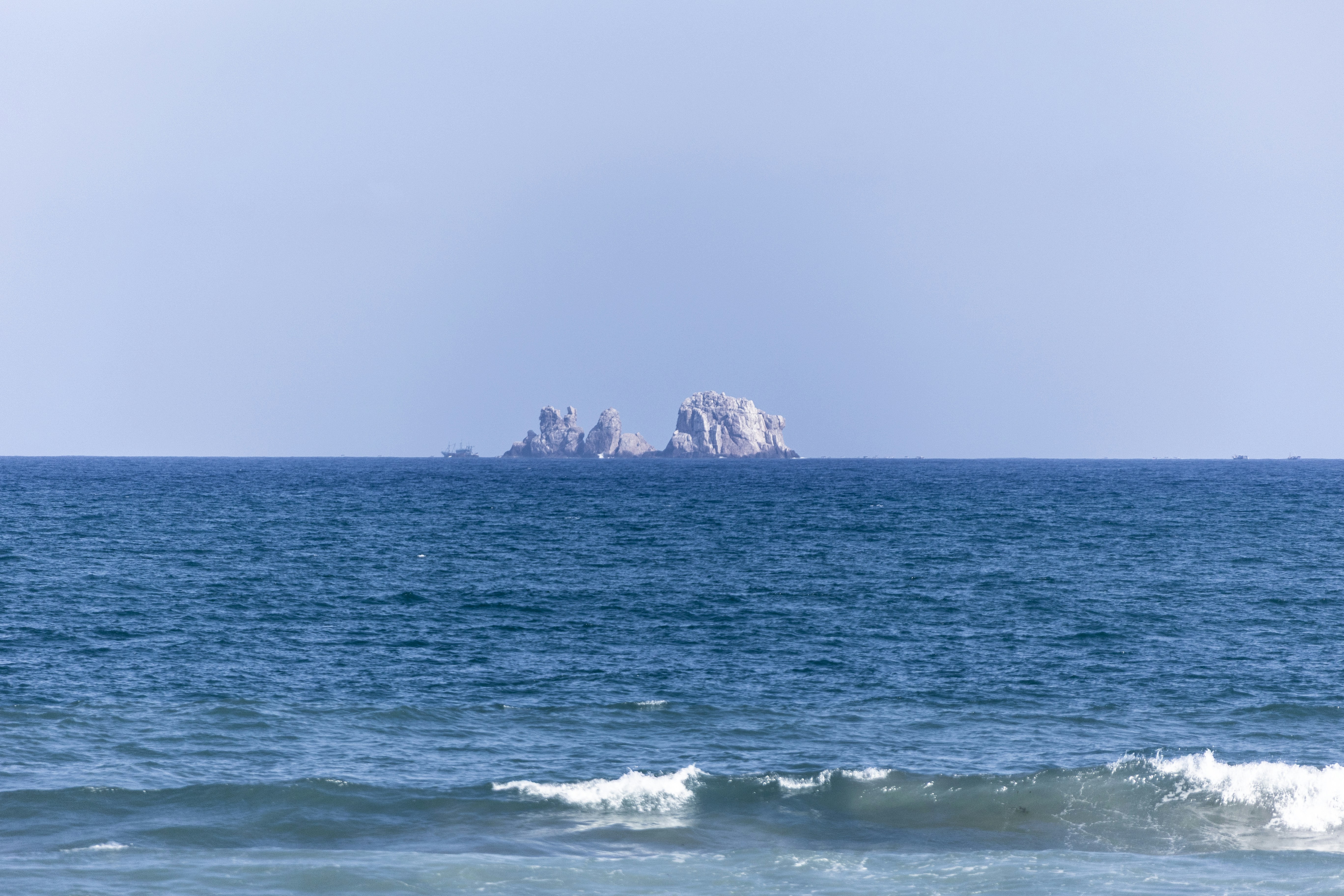 Isolated Seaward Peak: A Quiet Horizon with Distant Rock