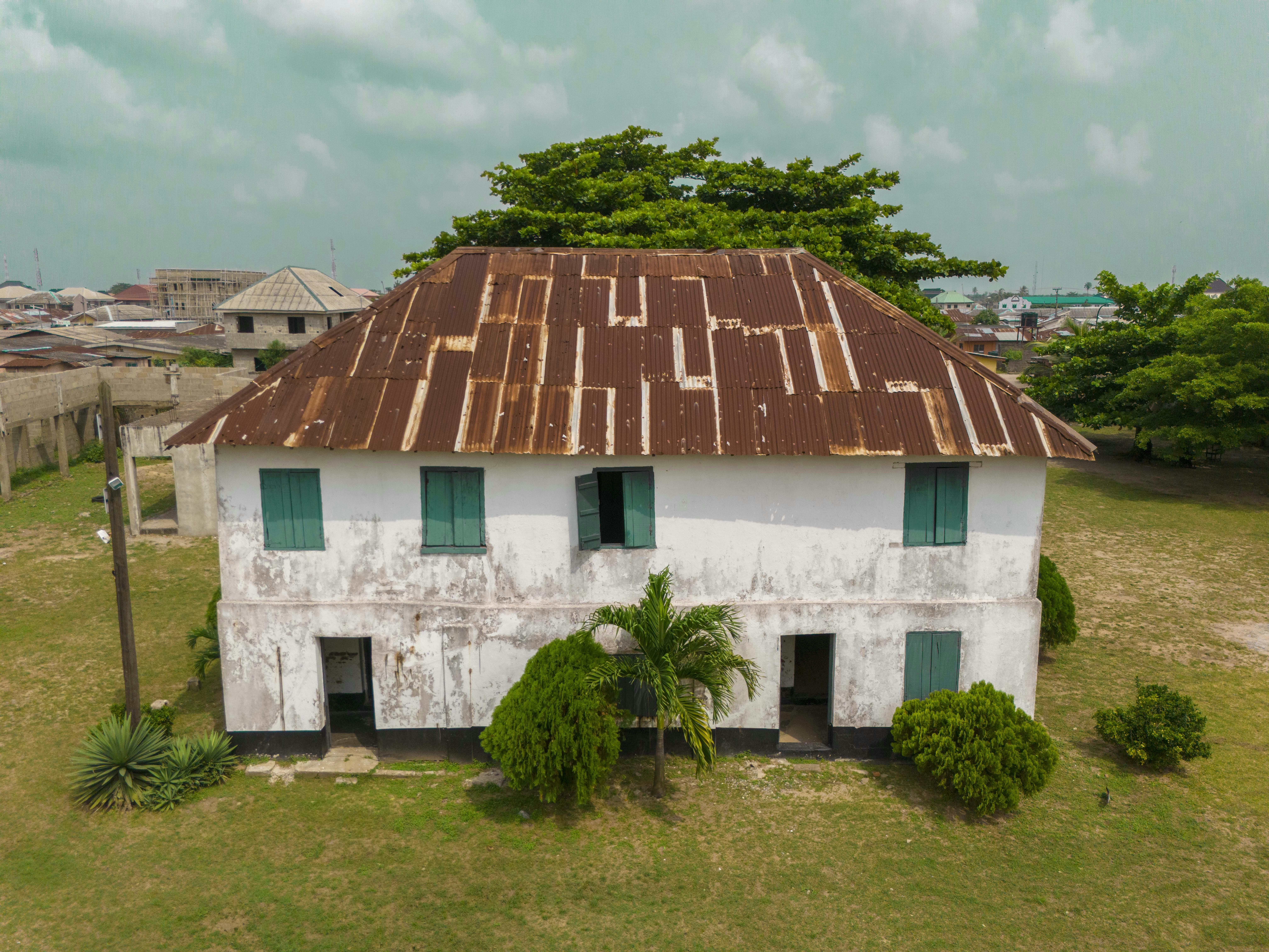 Rusting Roof, Whitewashed Walls: A Quiet Coastal House Under Cloudy Skies
